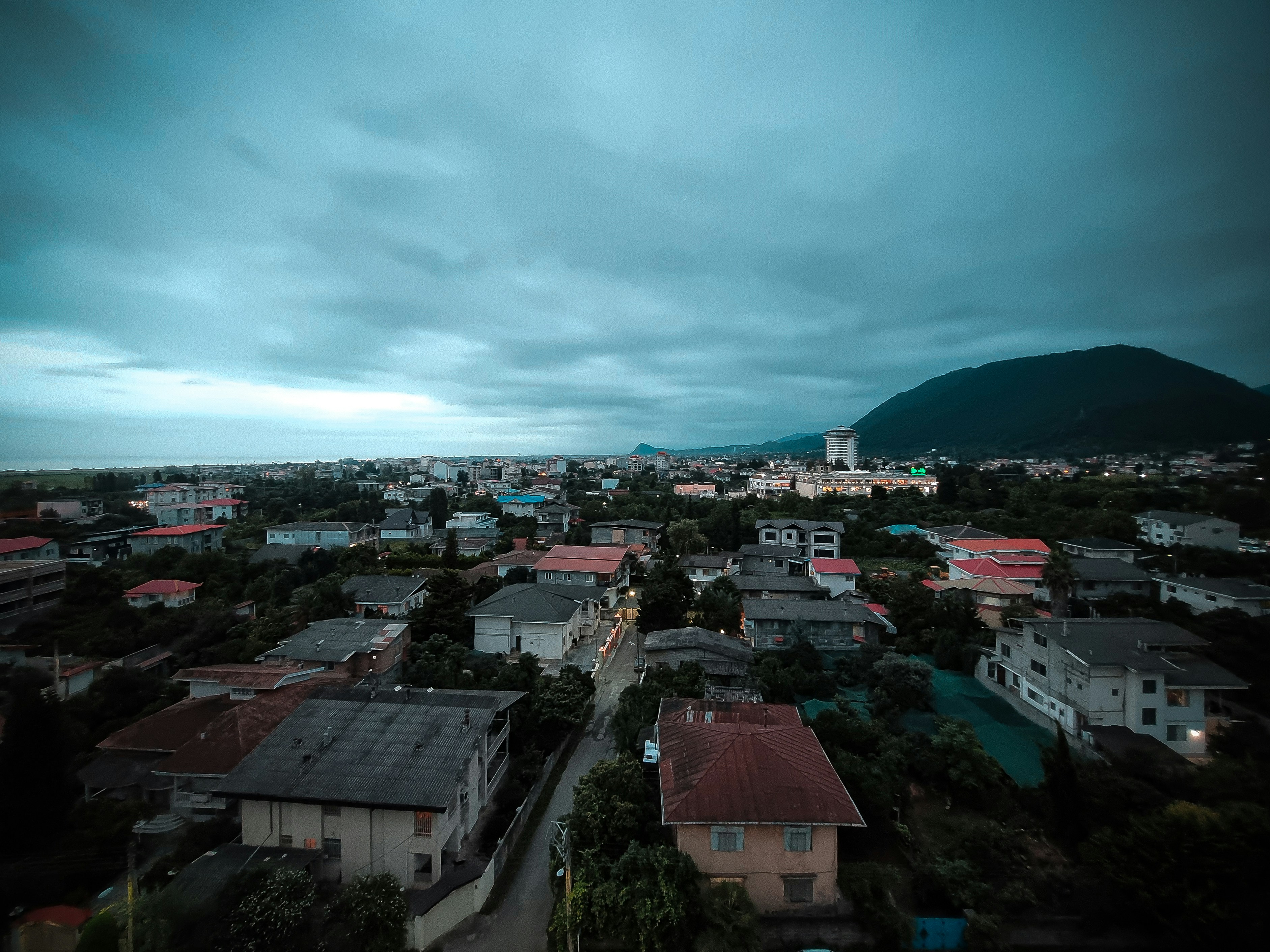 Twilight Corridor: Rooftop Grid Beneath a Blue Ridge