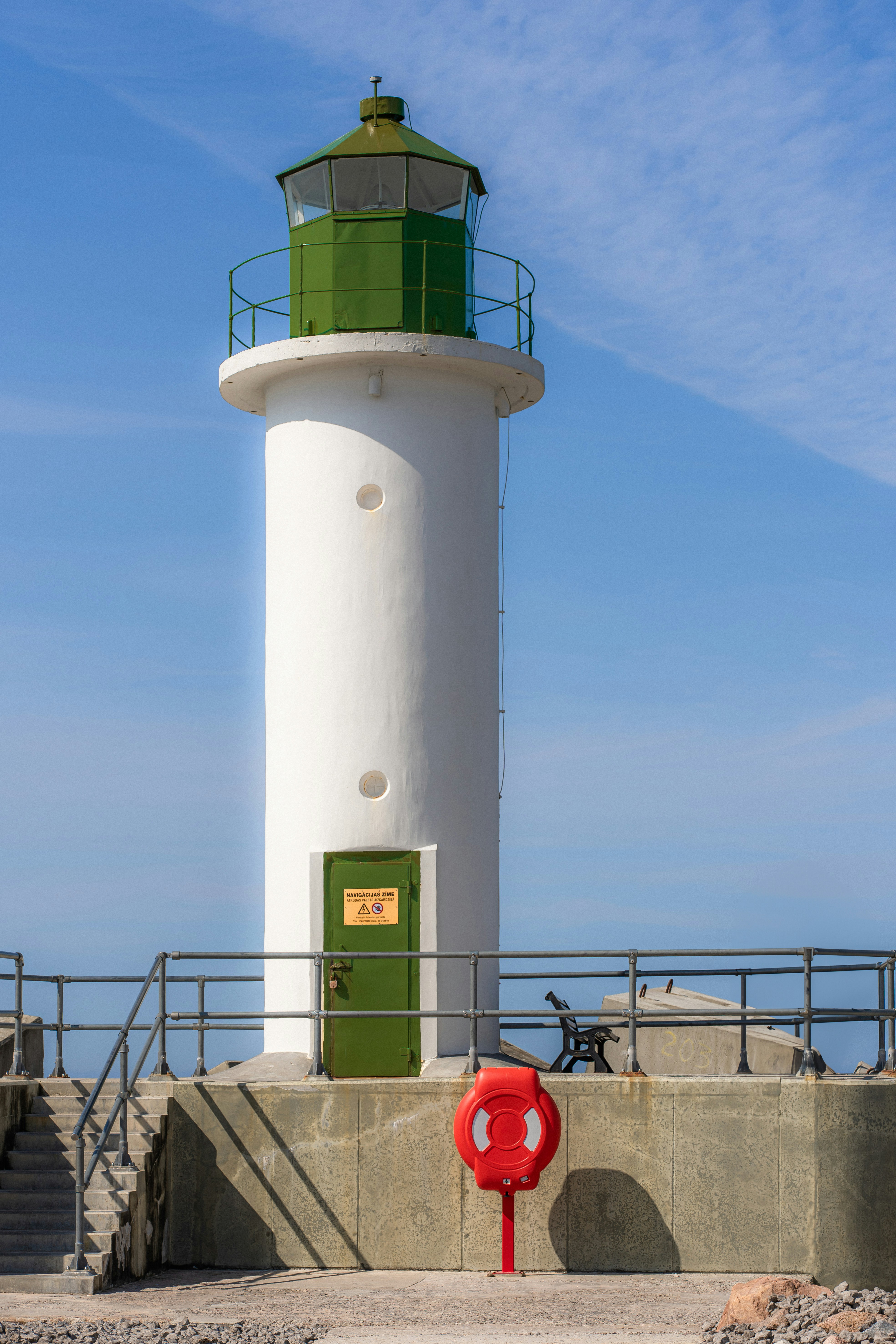 A white and green lighthouse with a red fire hydrant photo – Free ...