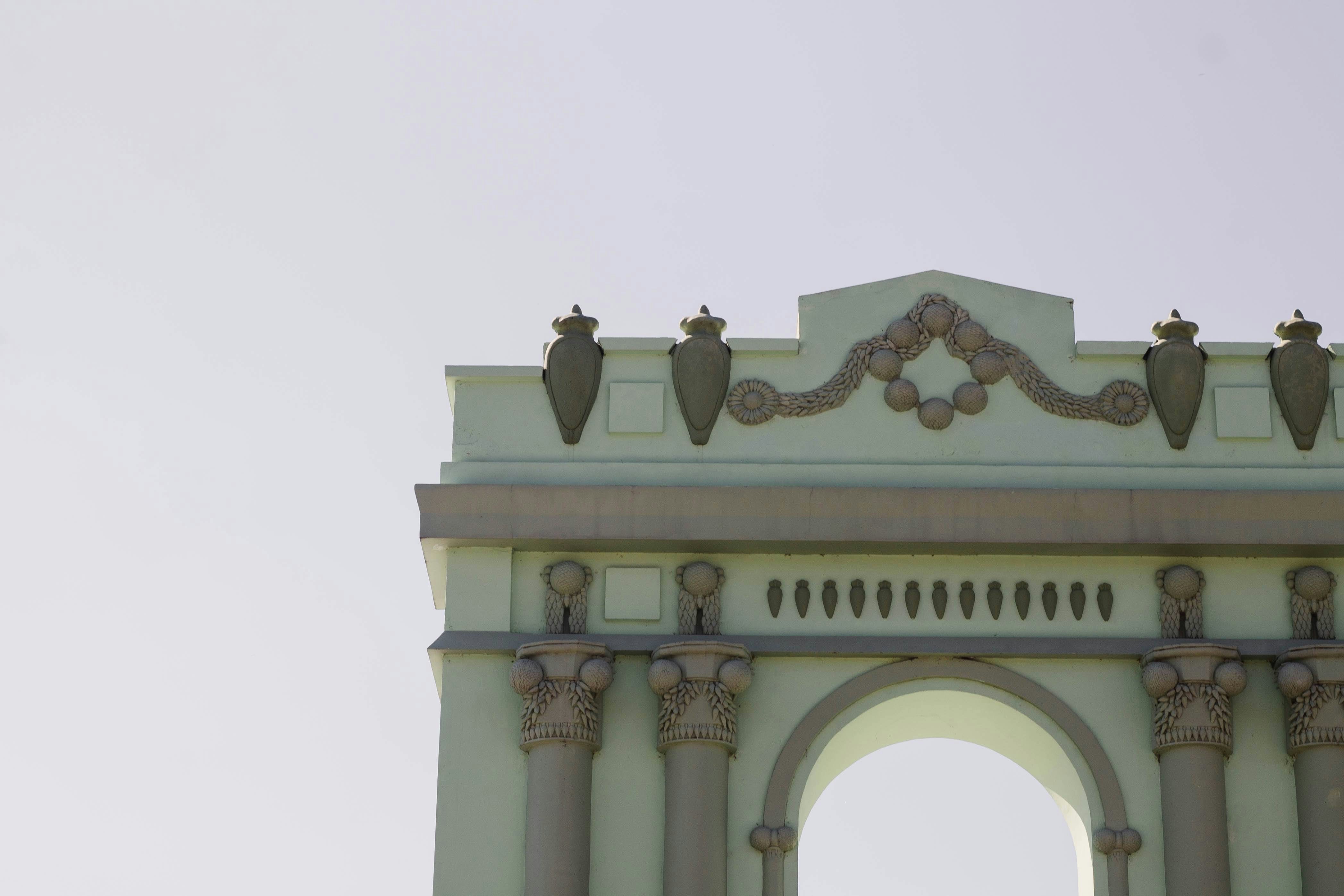 Mint Arch Crest: Delicate Ornamentation Under a Pale Sky