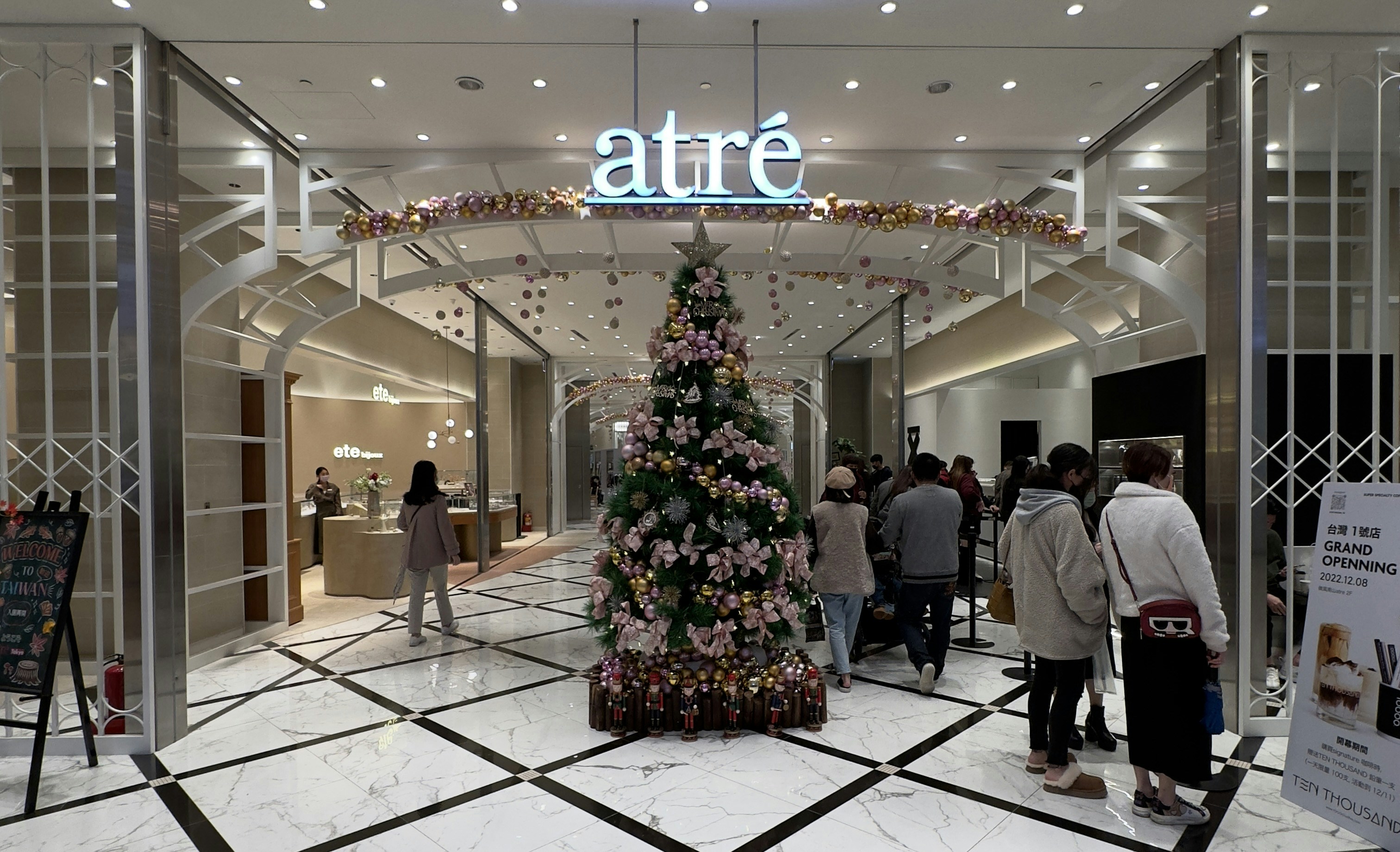 A group of people standing around a christmas tree photo – Free Breeze ...