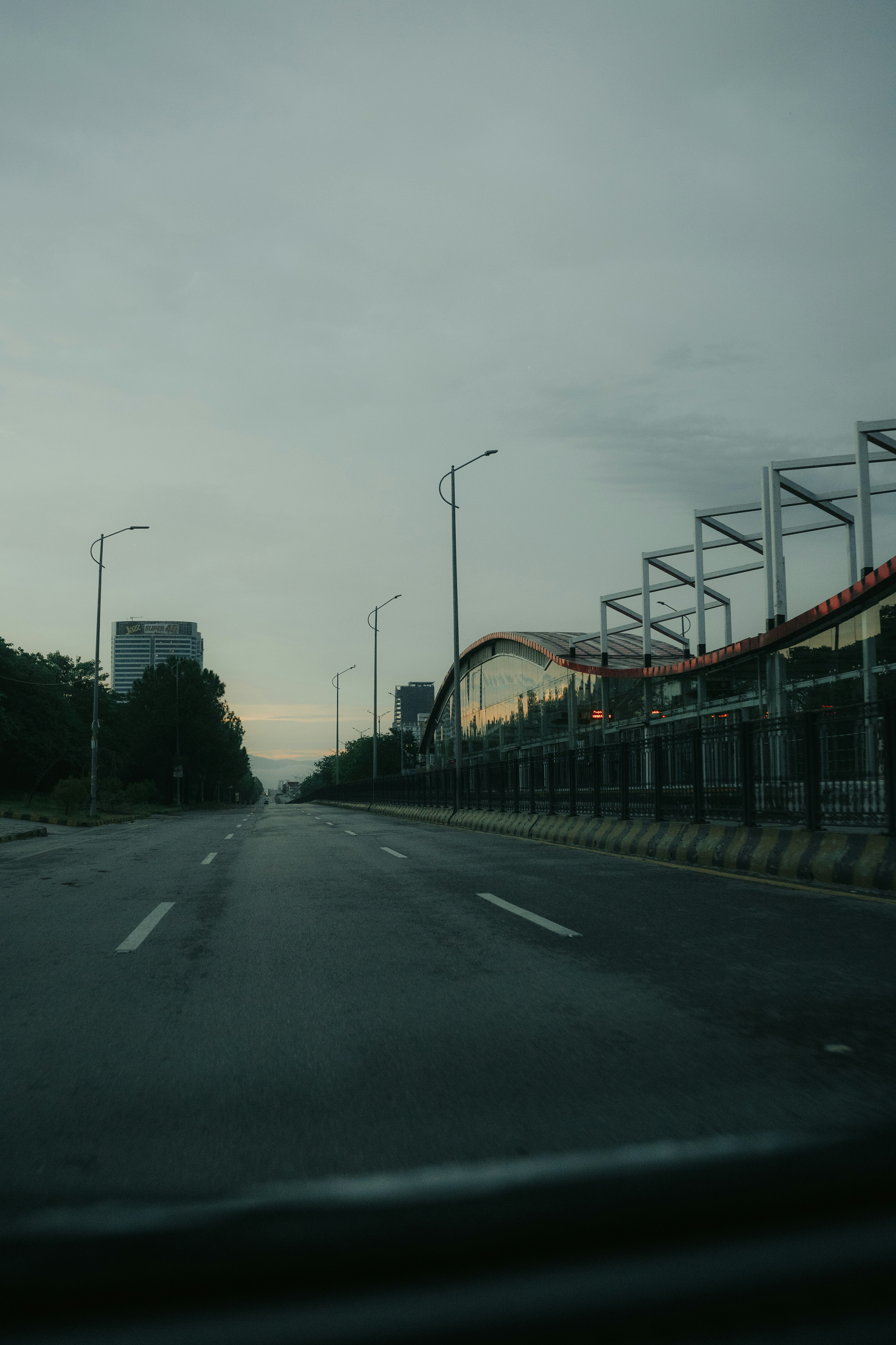 Dawn on an Empty Boulevard: The Road Toward a Distant Glass-Walled Skyline