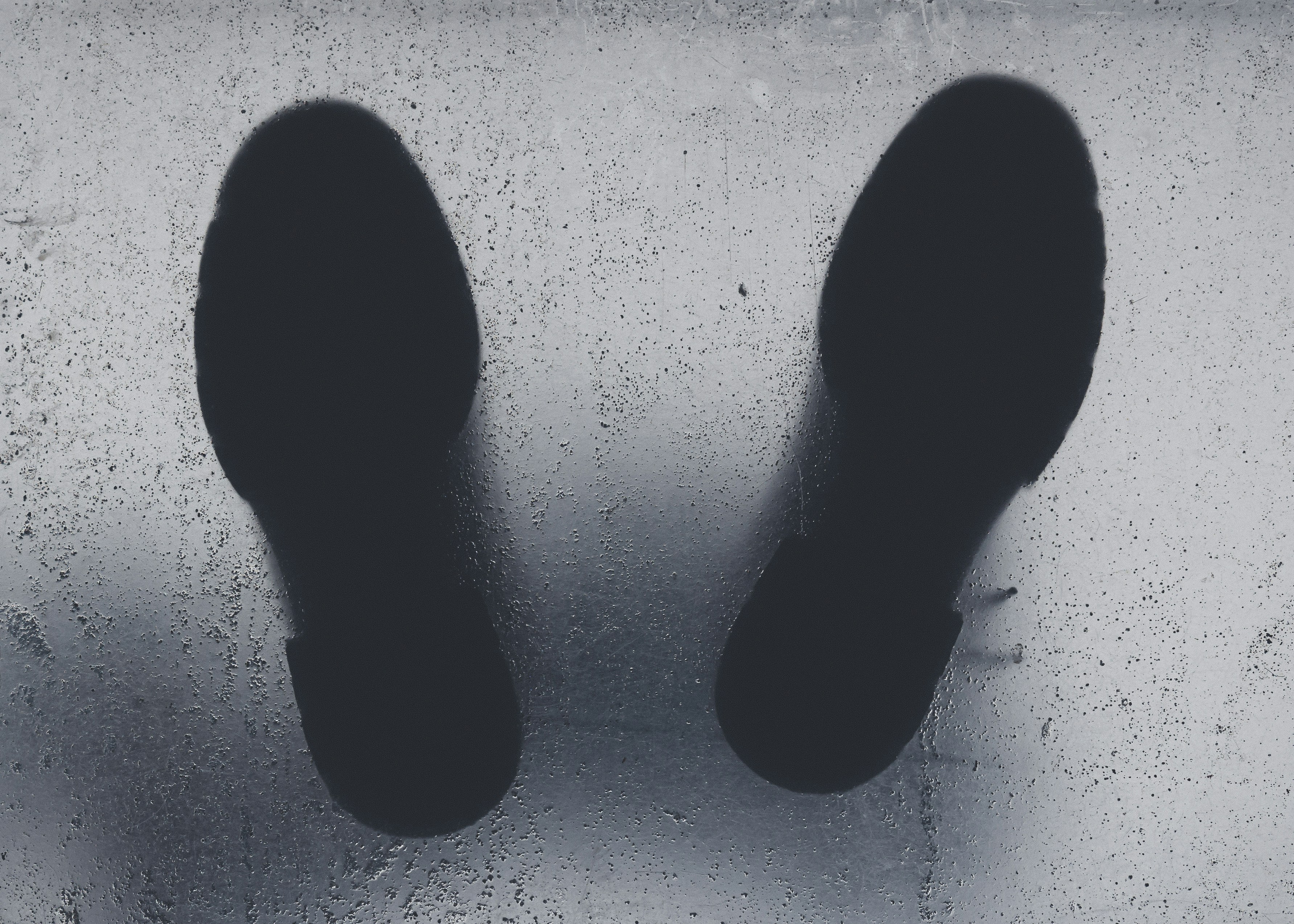 Overhead Silhouettes: Boots Paused on Frosted Glass