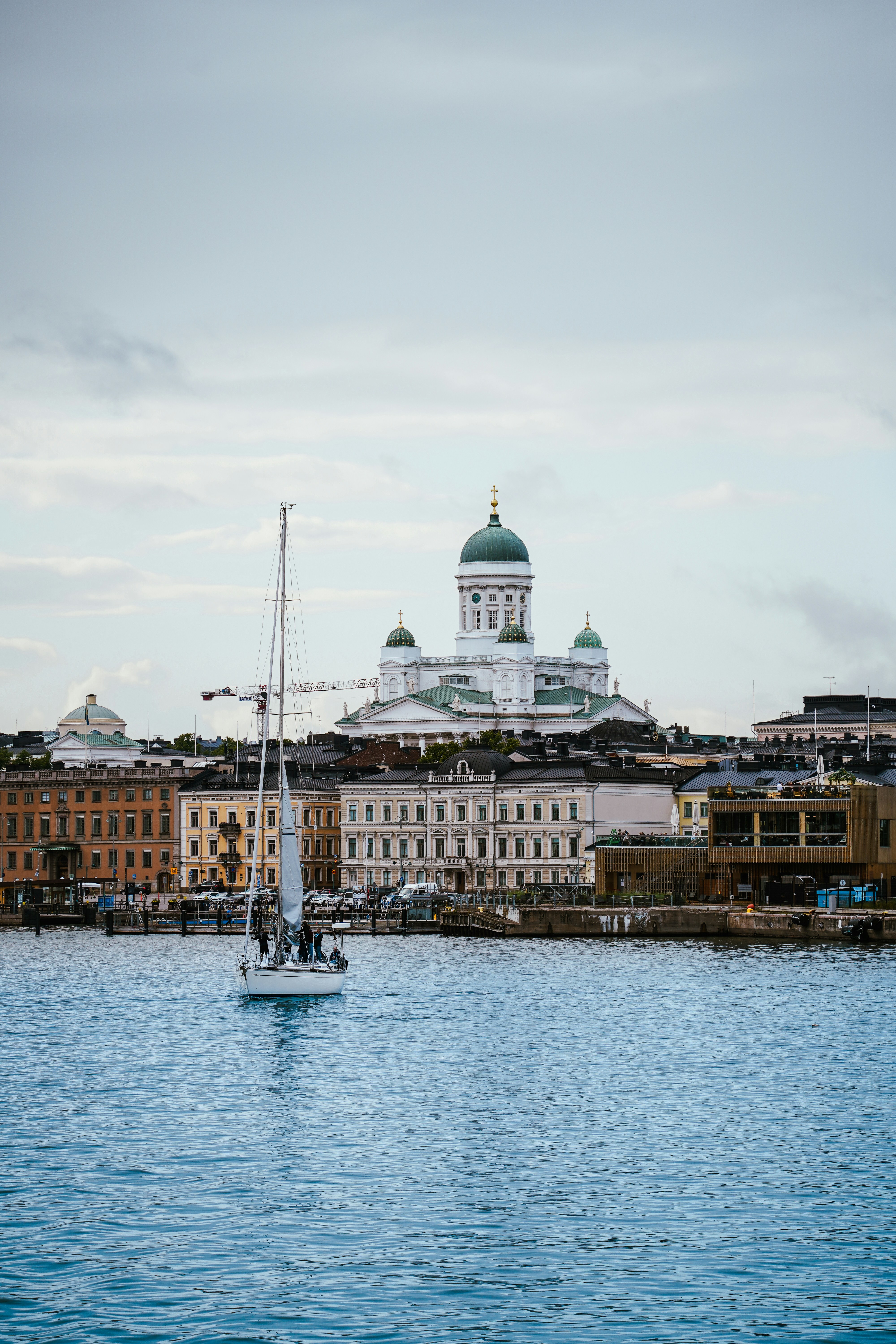 Harbor Vista: Sailboat Framing Helsinki Cathedral's Green Domes