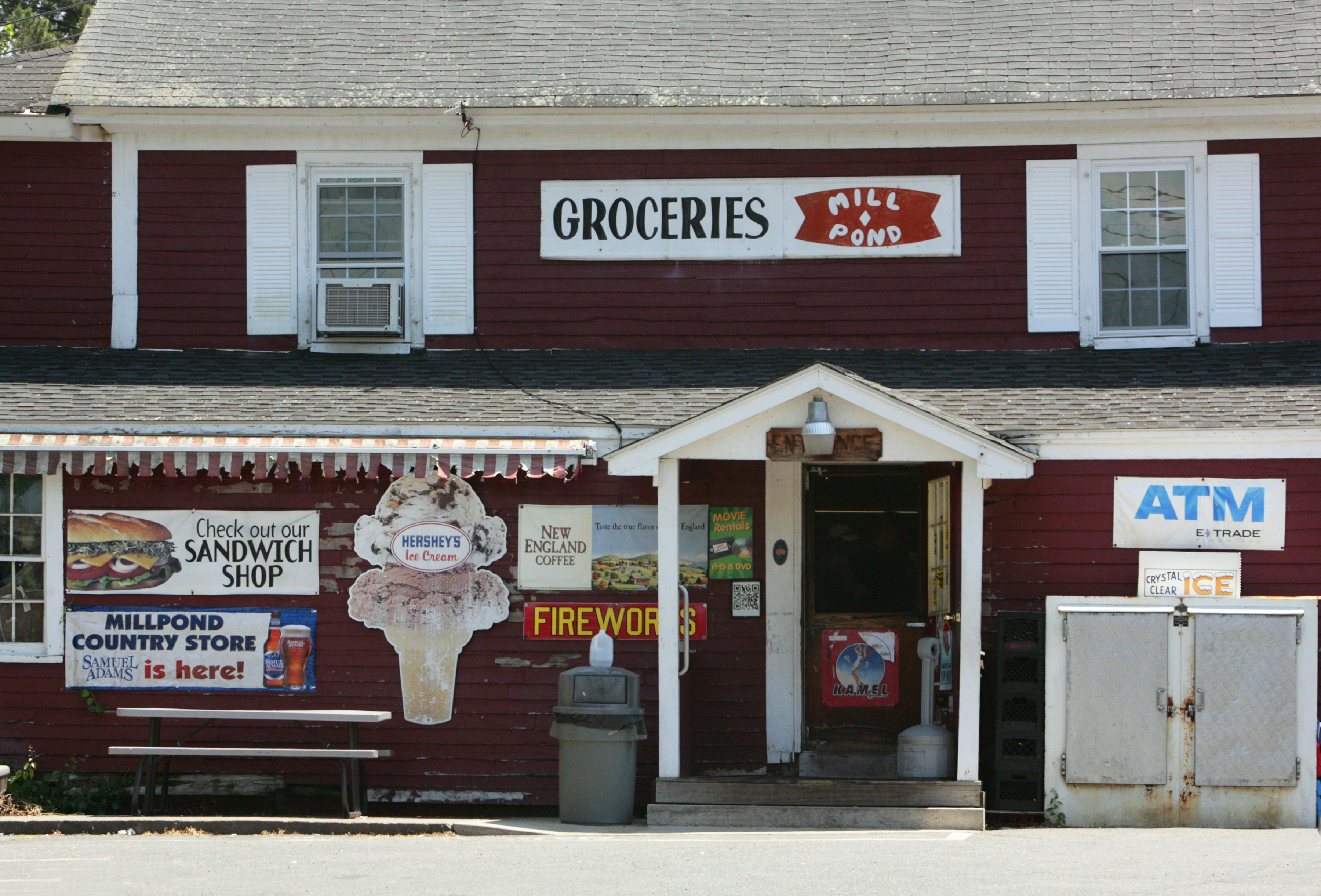 Front Facade of a Rustic Rural Groceries Store with Signage and Ice Cooler