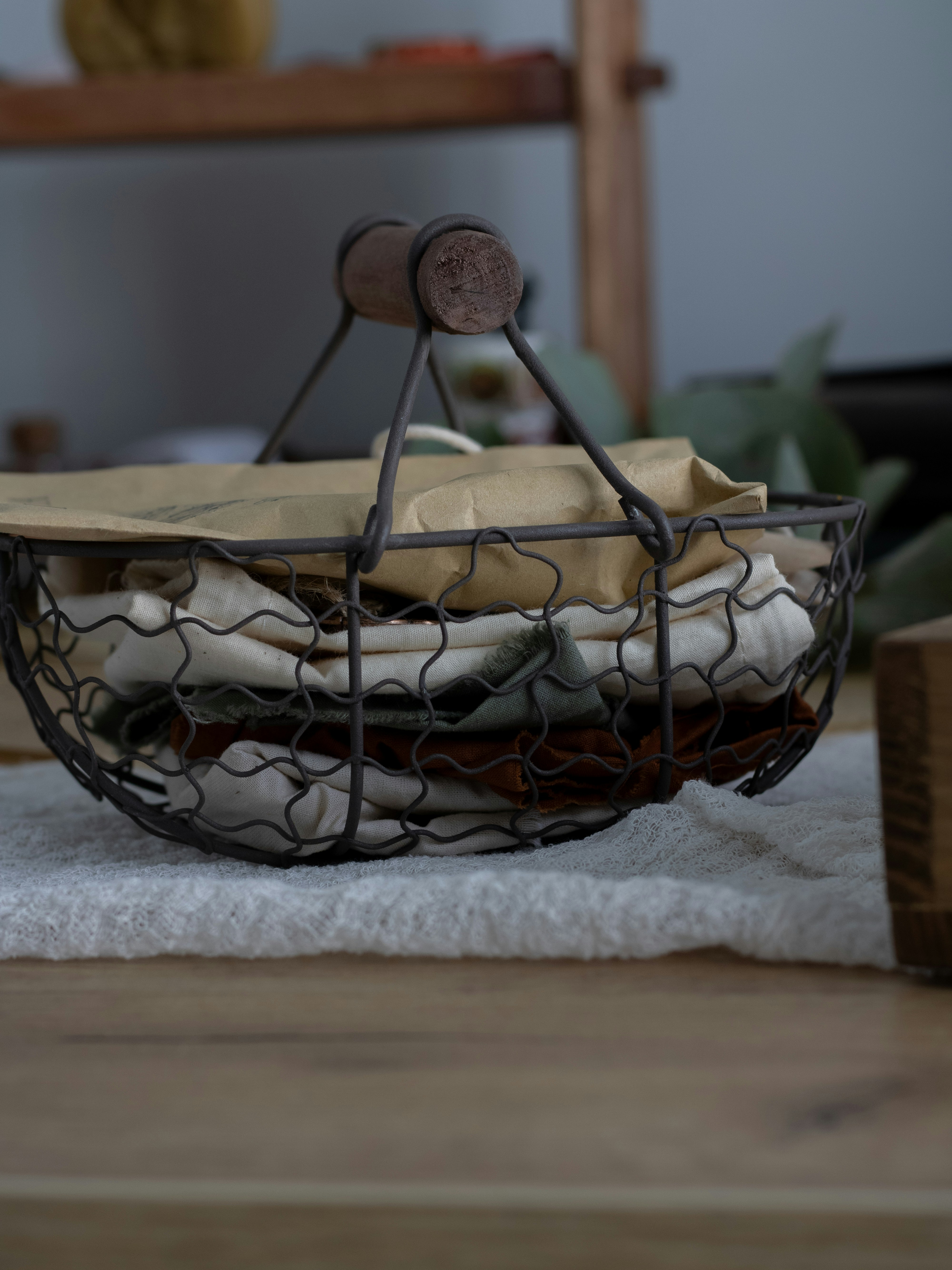 Linen Nest in a Rustic Wire Basket on a Wooden Table
