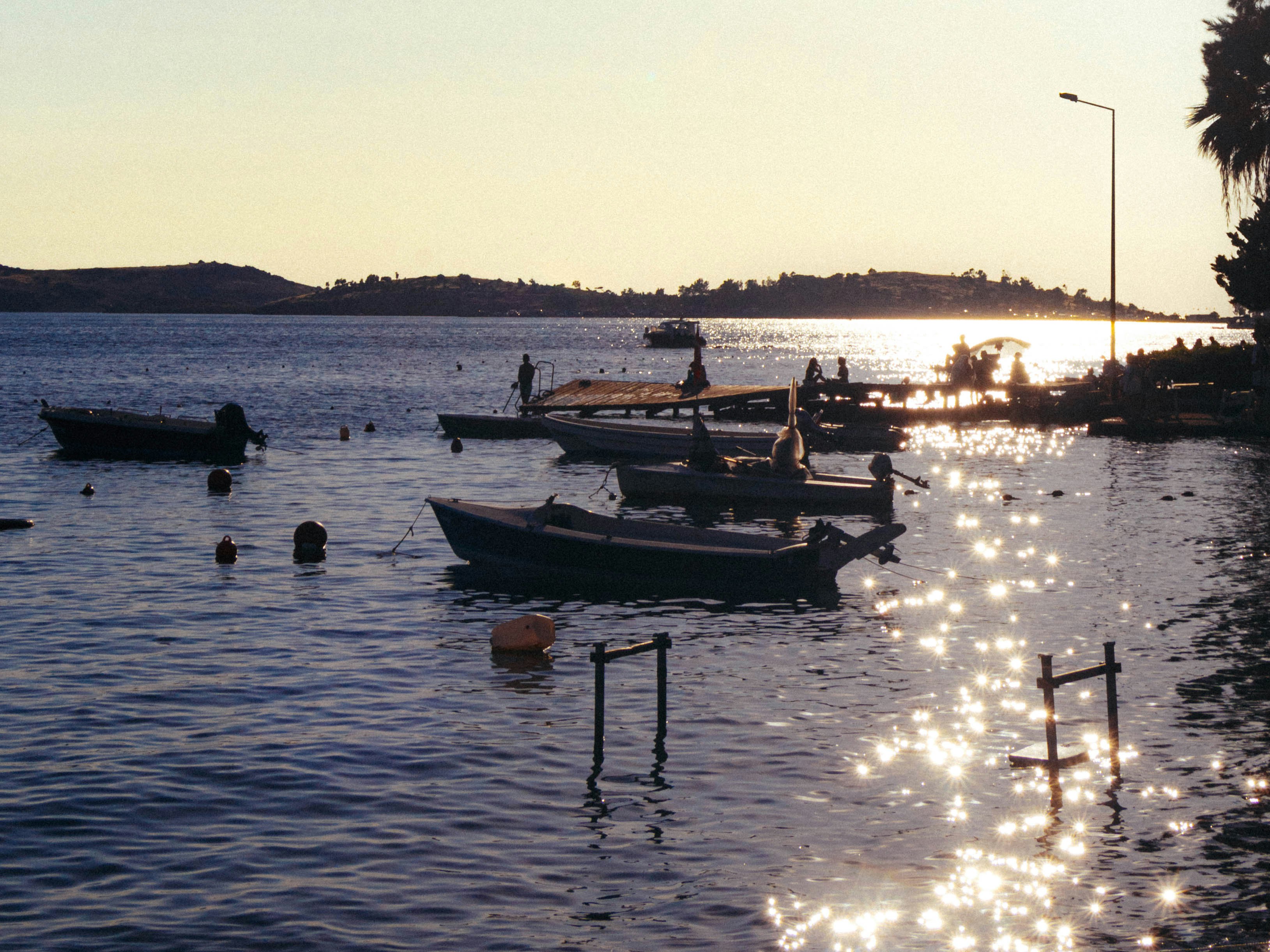Sunlit Boats Quietly Rest on a Silvered Water at Dusk