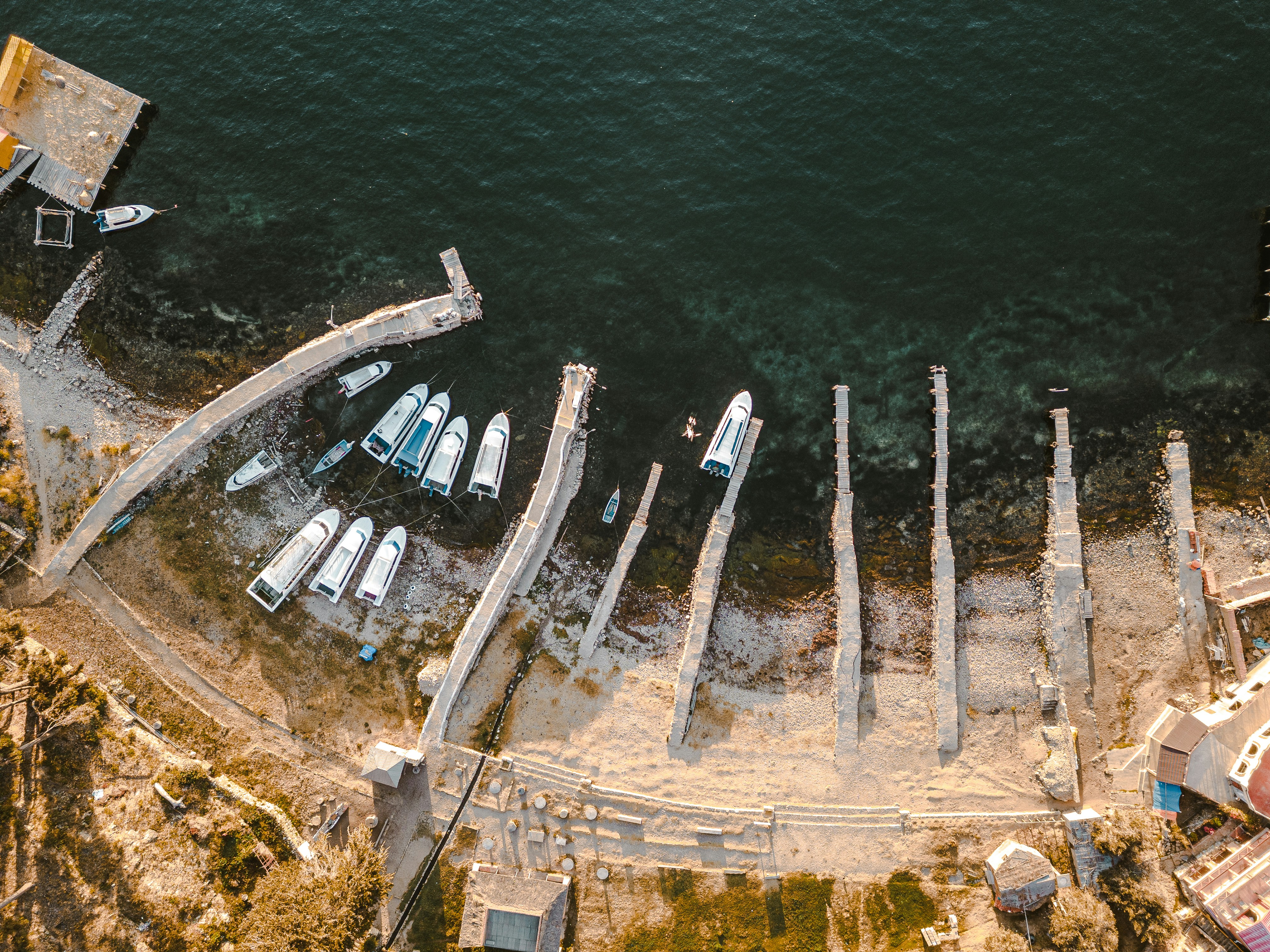 Curved Marina: Aerial Portrait of Boats Nestled Along Weathered Piers