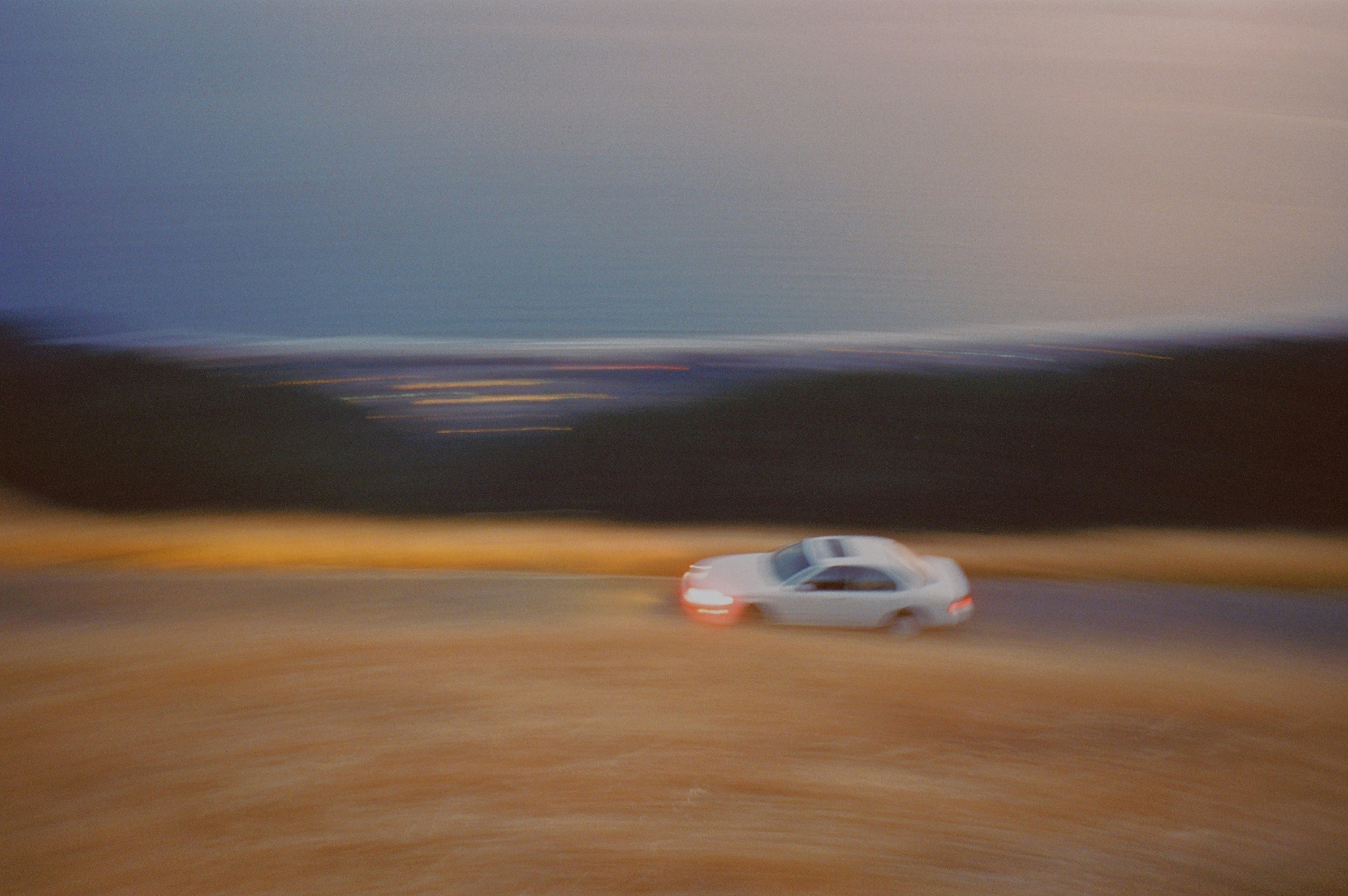A blurry photo of a car driving down a road photo – Free Wallpapers ...