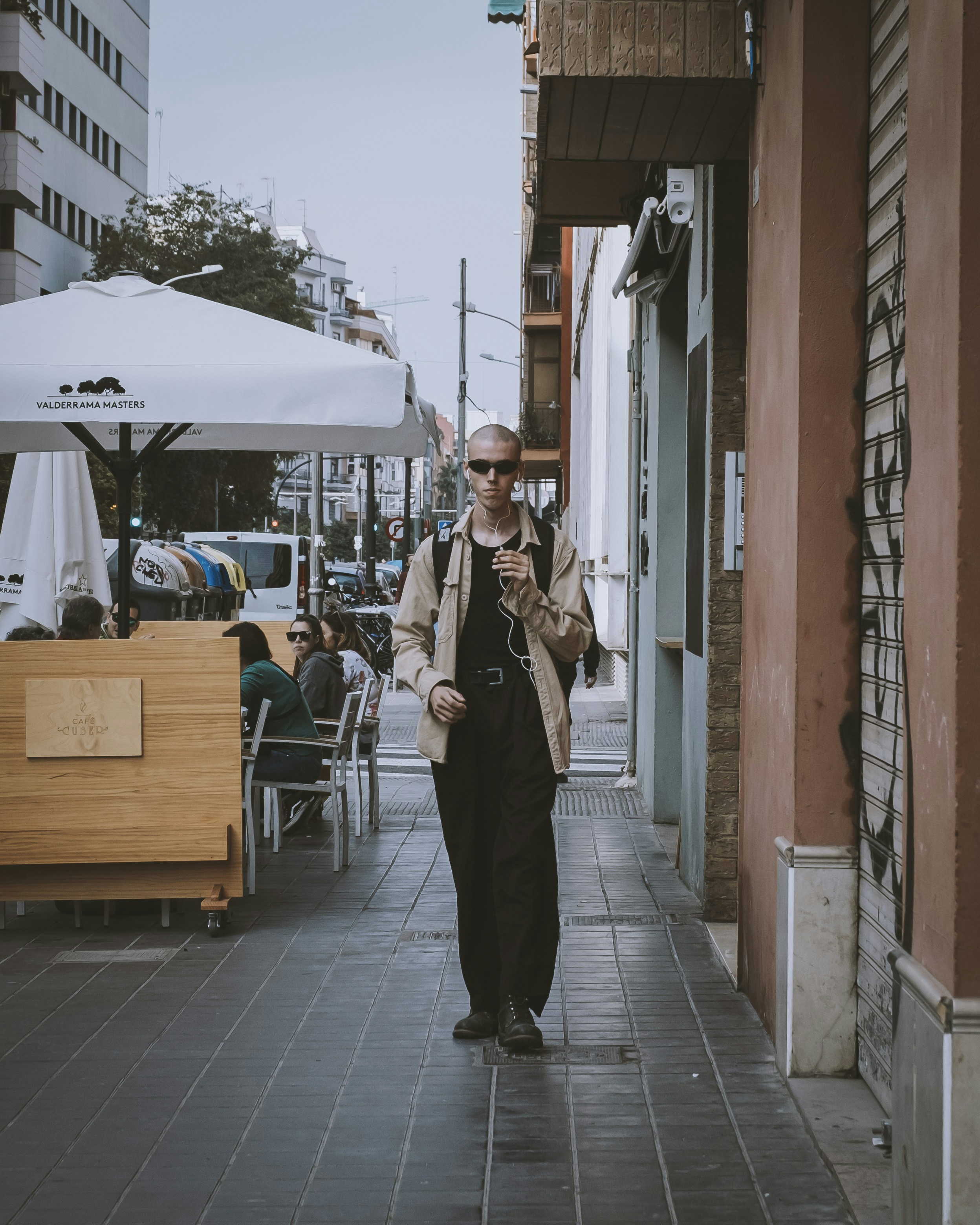 Trench-Coat Stroll Through a Sunlit Café-Lined Street