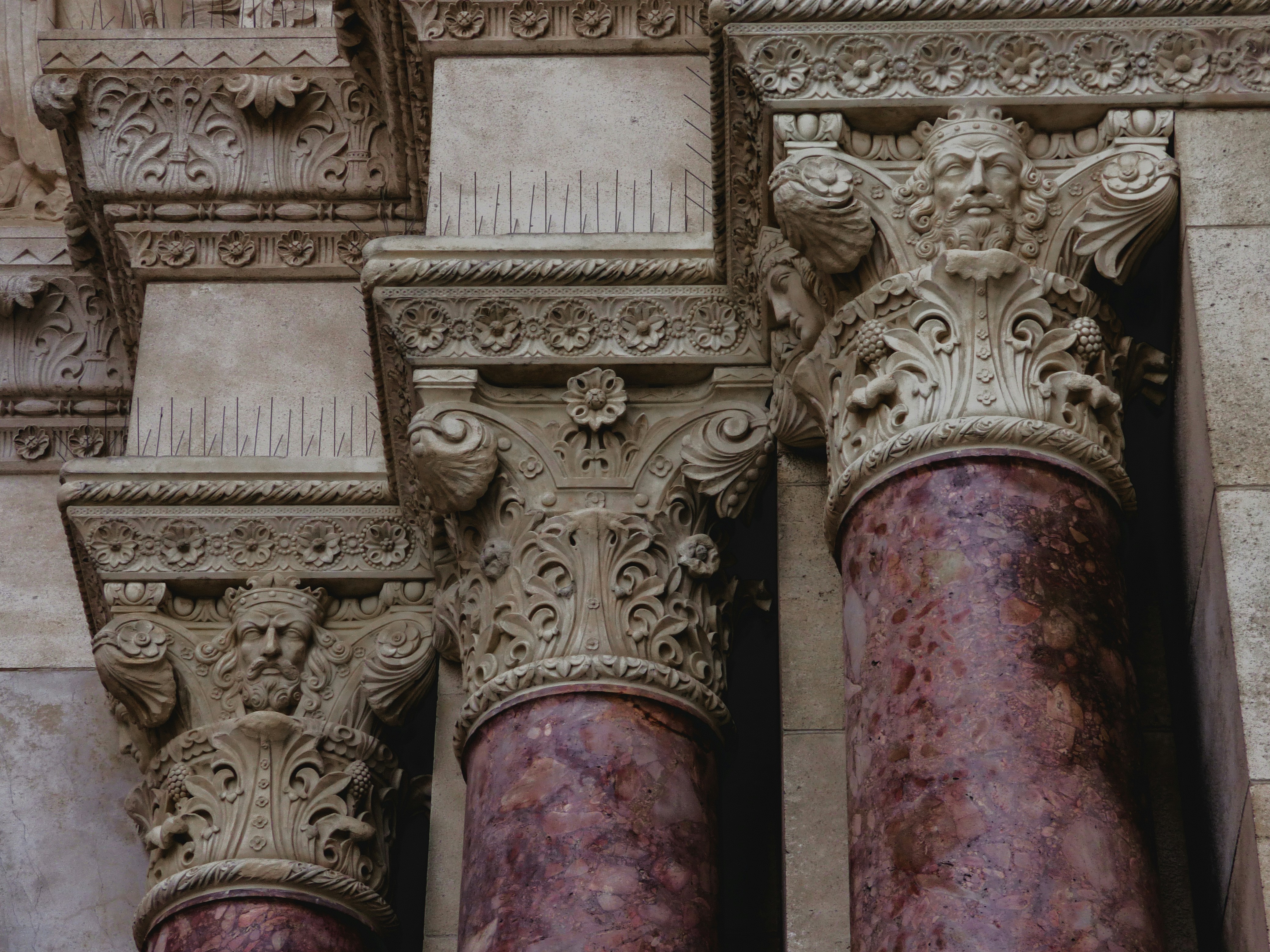 Stone Crowned Facade: Corinthian Capitals in Weathered Marble