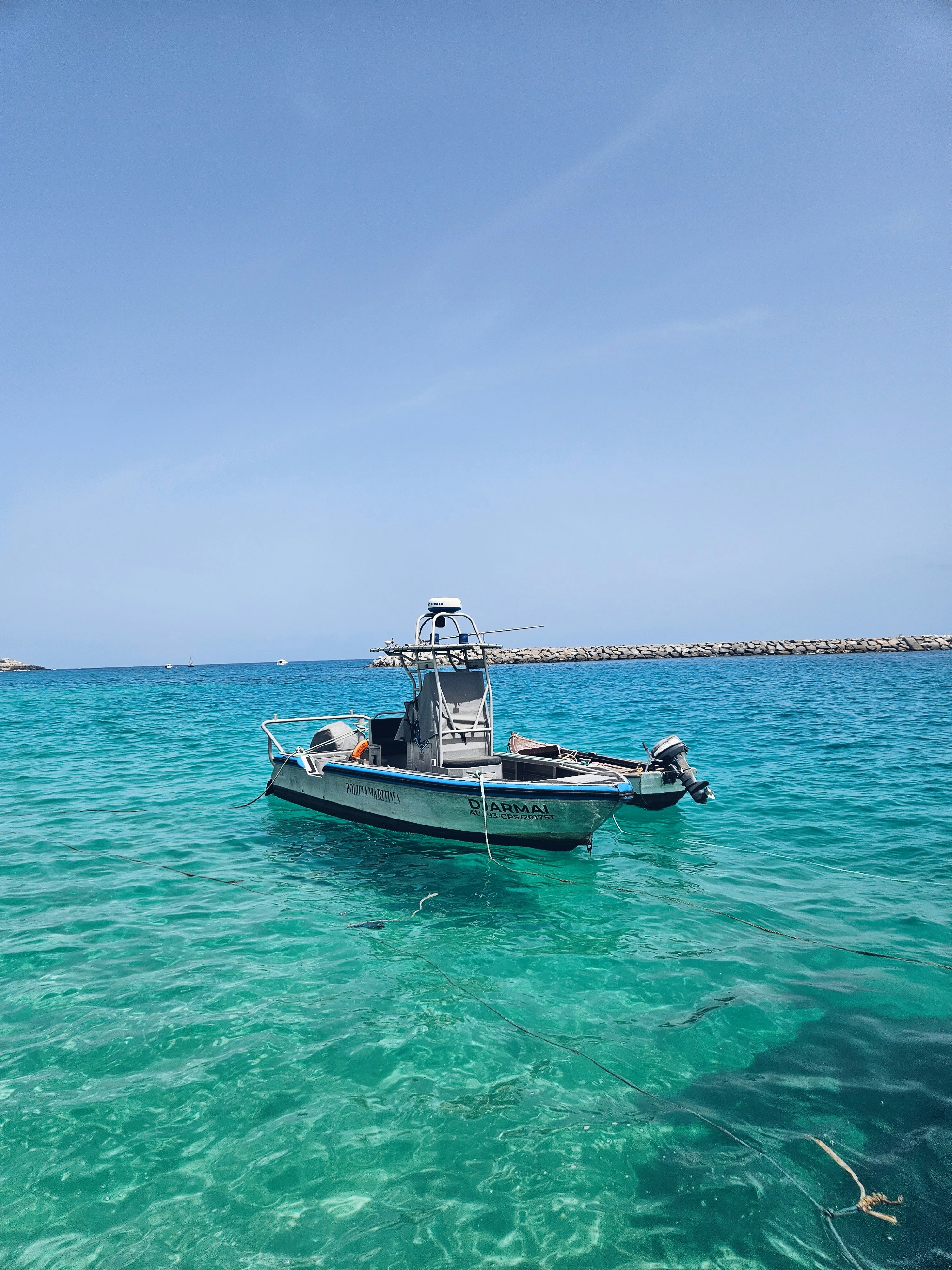 A small boat floating in the middle of the ocean photo – Free Maio ...