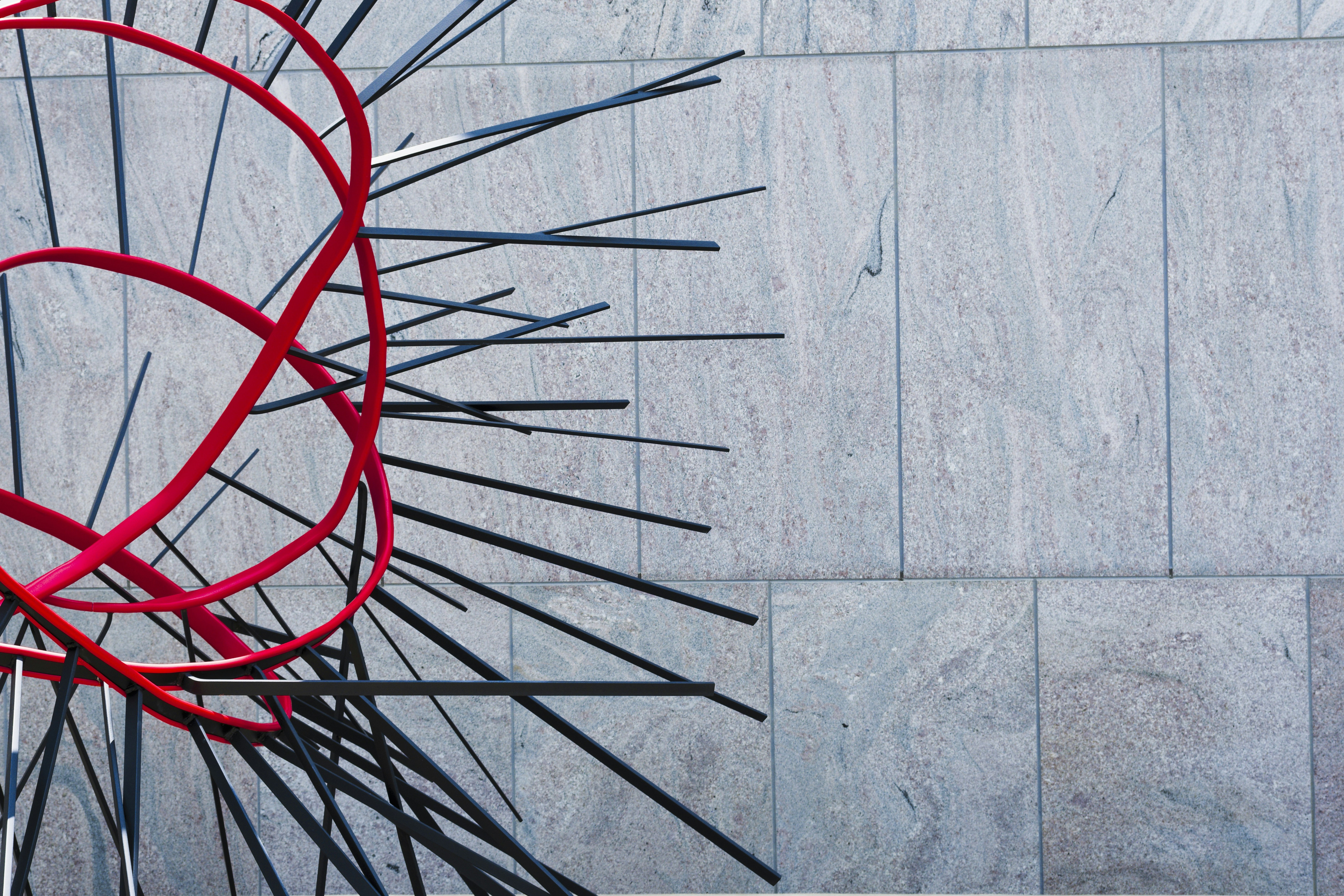 Crimson Rings Orbit a Spoked Constellation Against a Stone Canvas