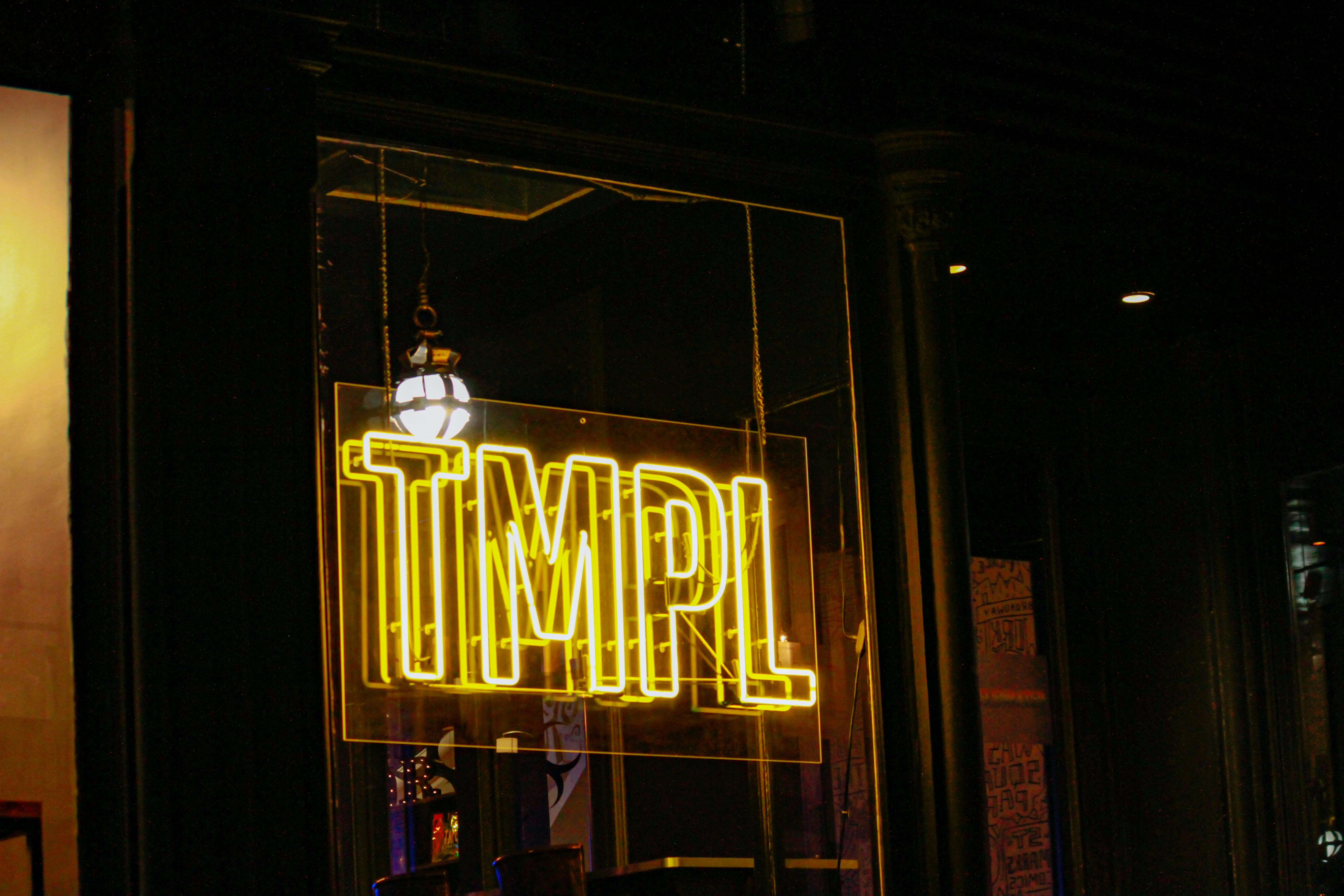 Midnight Neon: The TMPL Sign in a Dim Shopfront