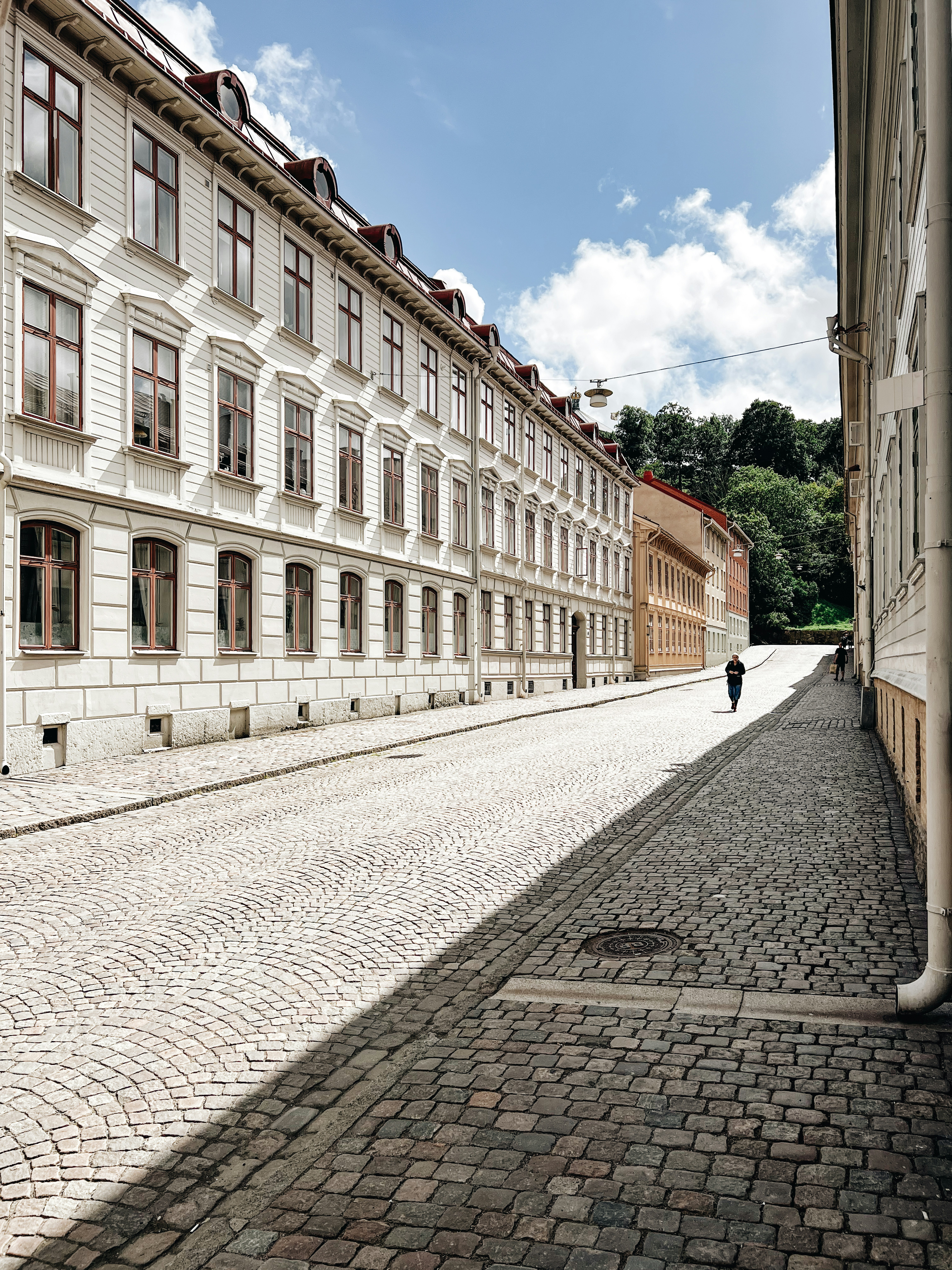 Vanishing Light Along a White-Walled European Street