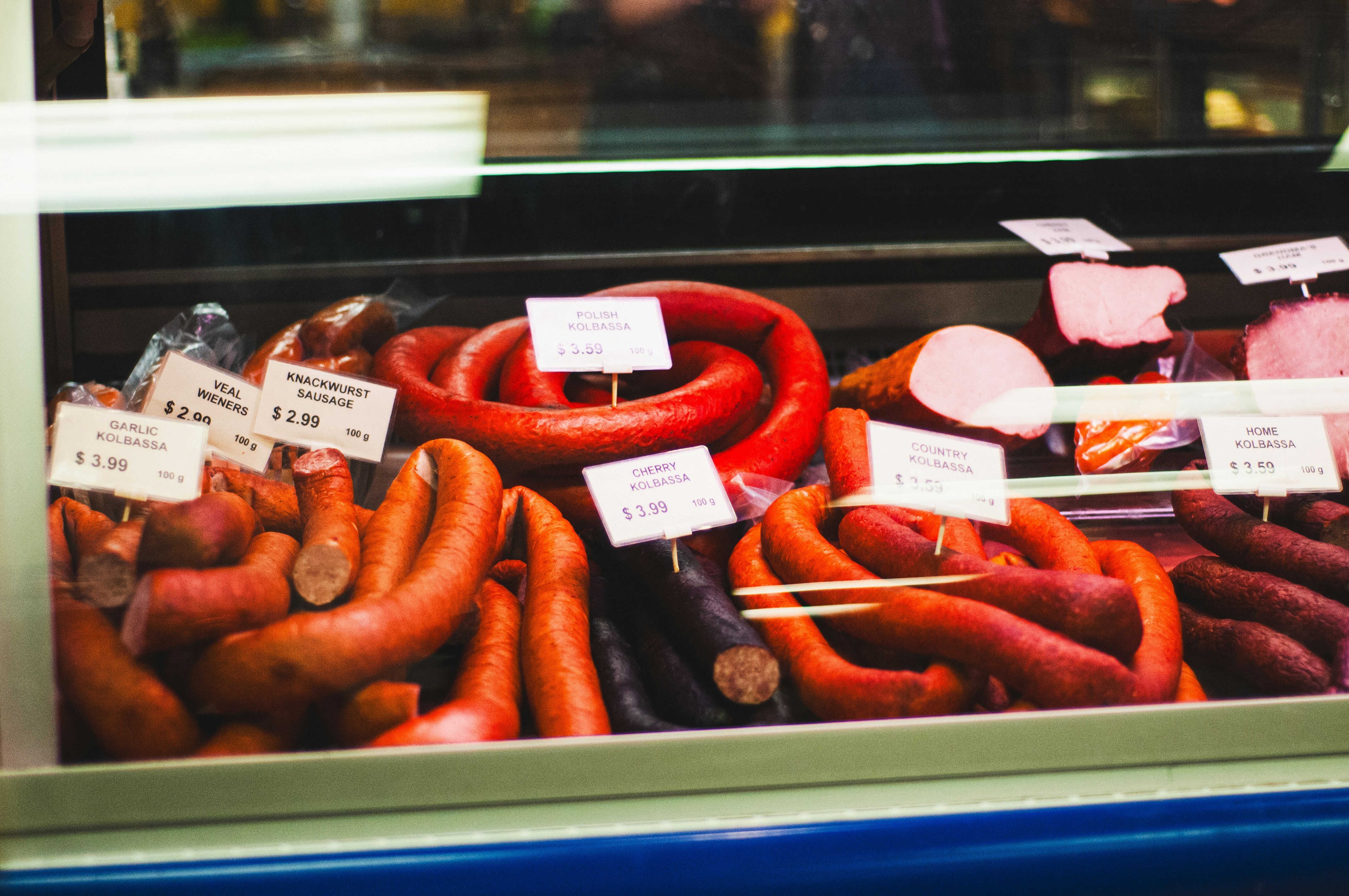 Curved sausages in a market window glow