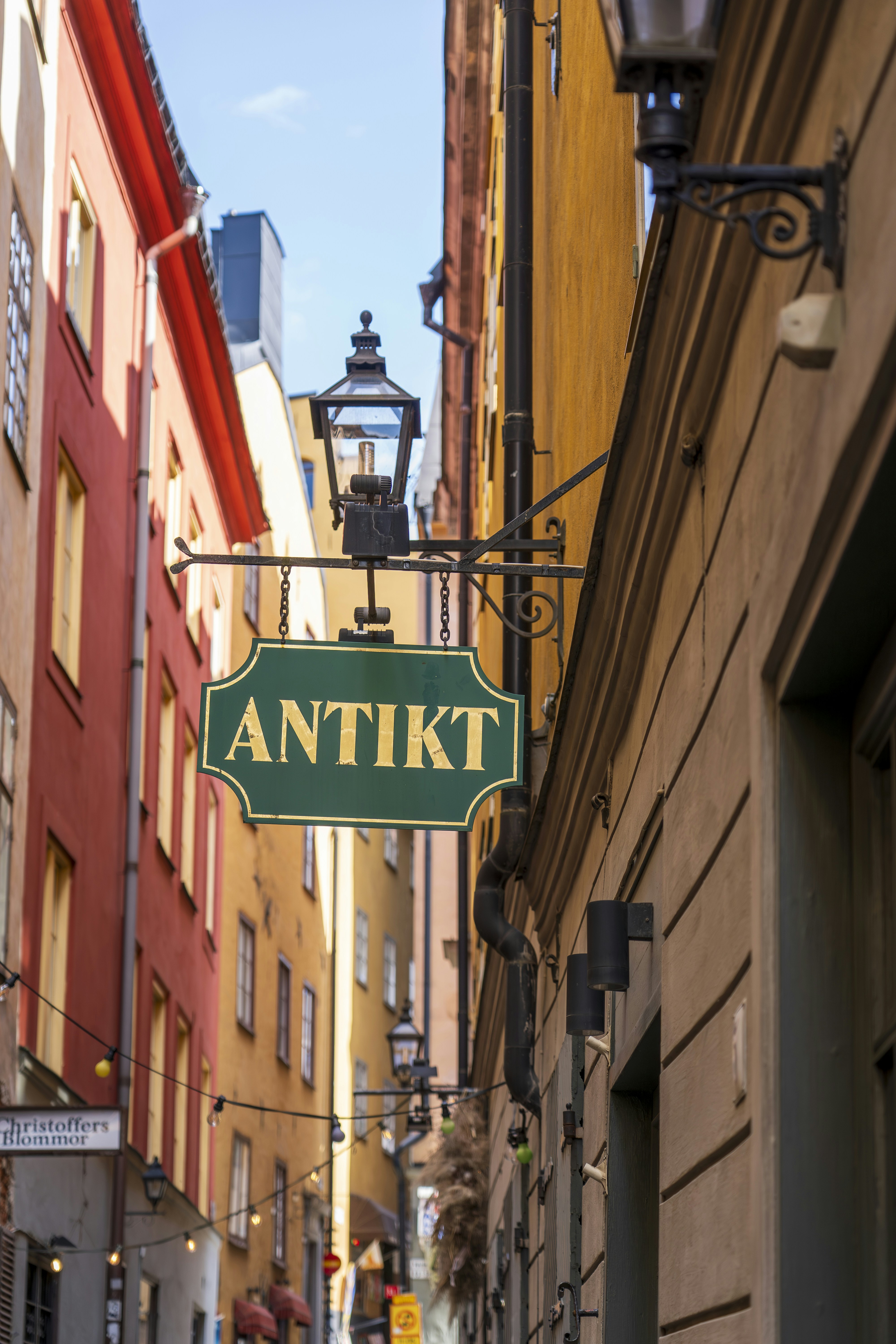 Antik Sign Amid Colorful Facades in a Sunlit European Alley