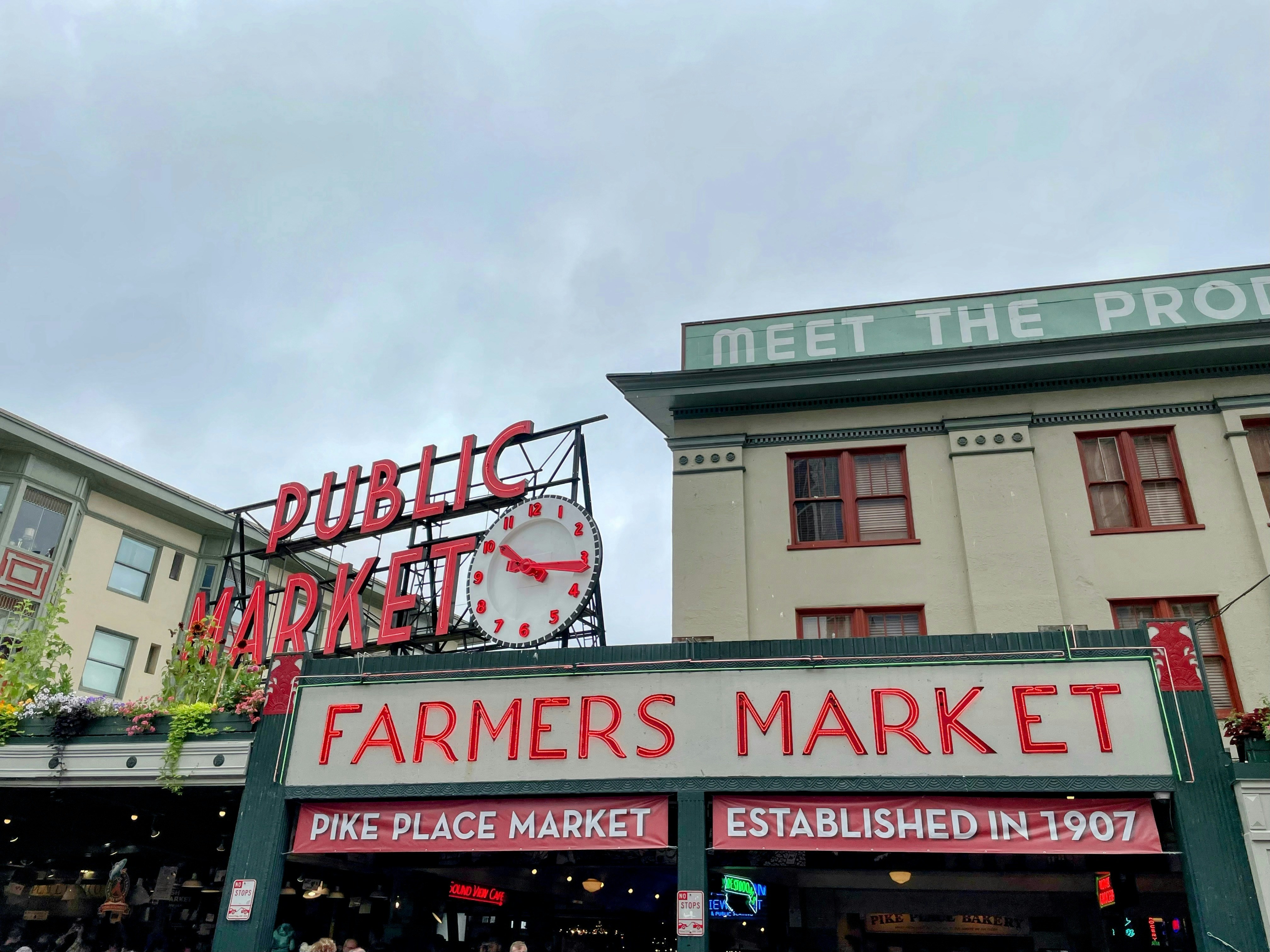 Vibrant entrance to Pike Place Market featuring iconic signage and bustling activity. The historical architecture adds character to this urban hub.