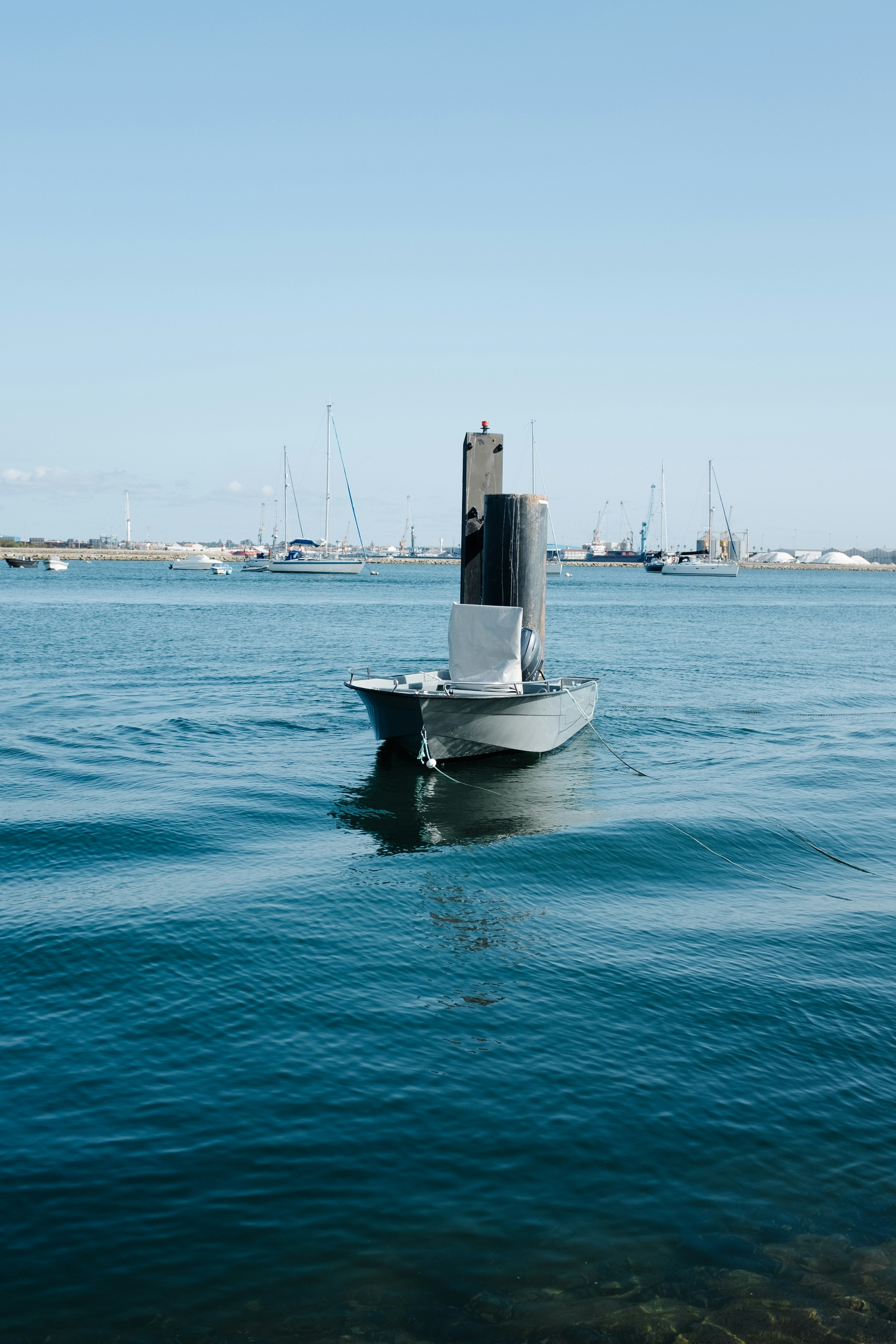 Midfield Vessel resting beside a moored jetty under a calm, blue sky