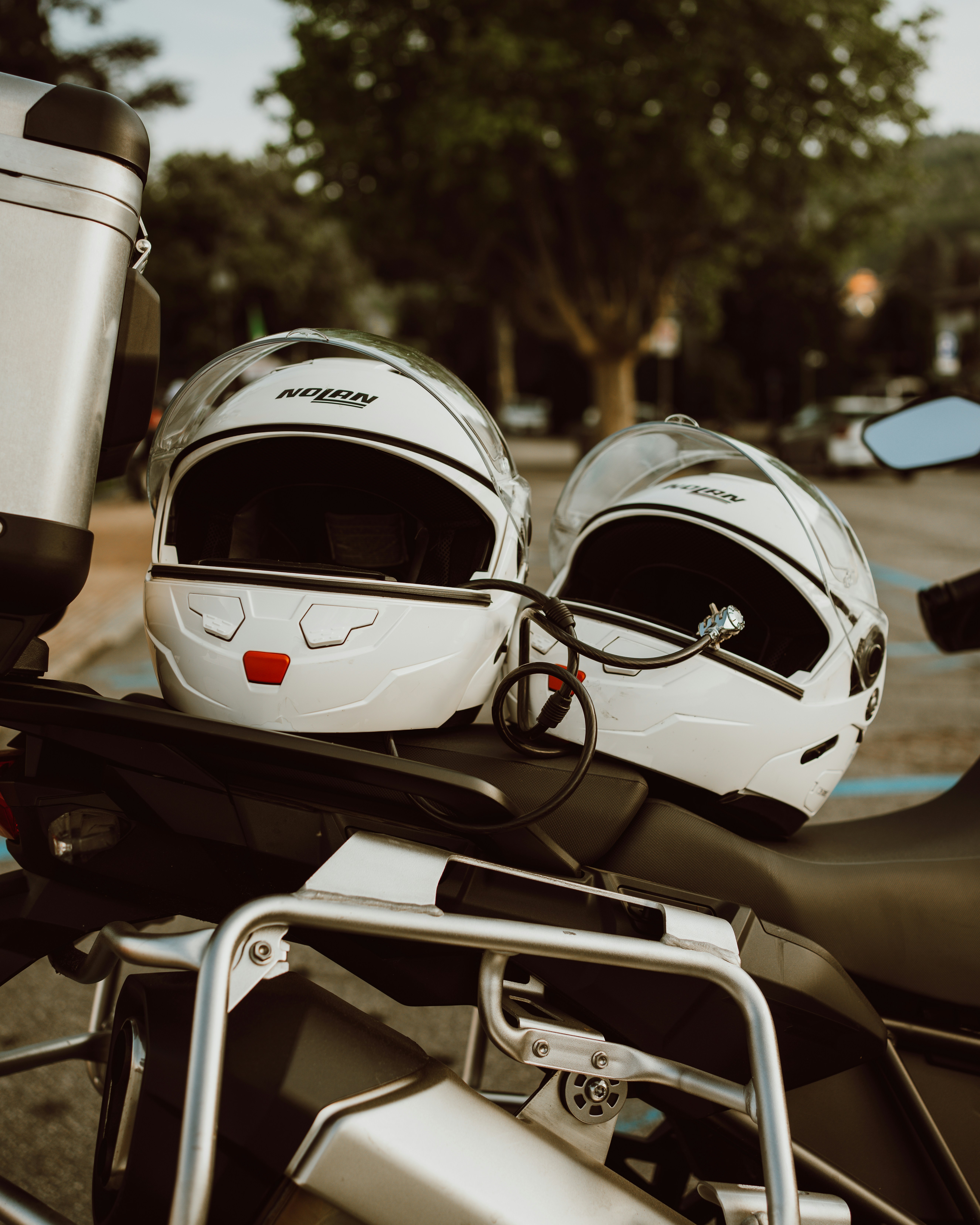 A motorcycle with two helmets on the back of it photo – Free Wallpaper ...