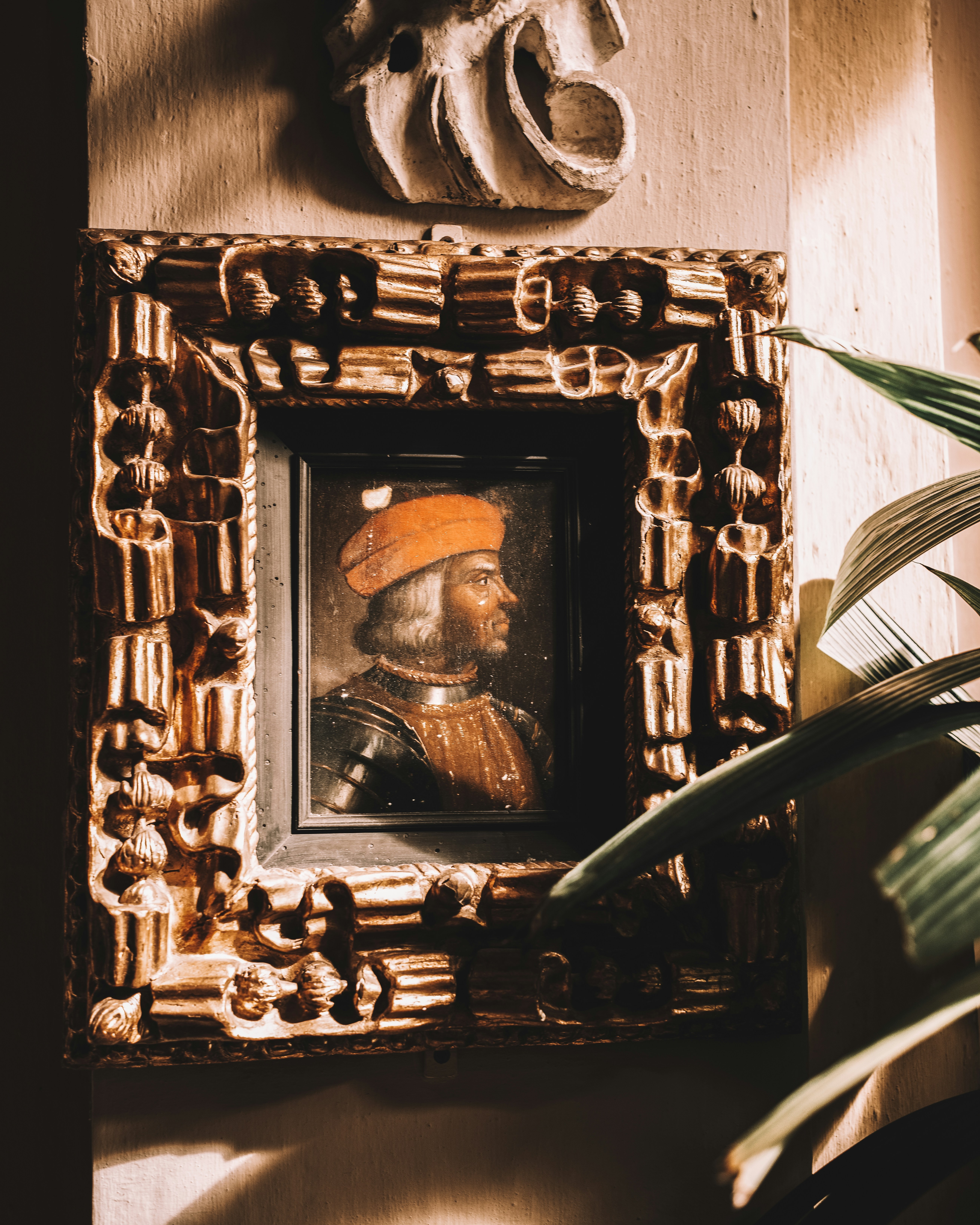 Tiny Portrait, Big Frame: A Medieval Framed Figure Adorns Soft Sunlit Wall
