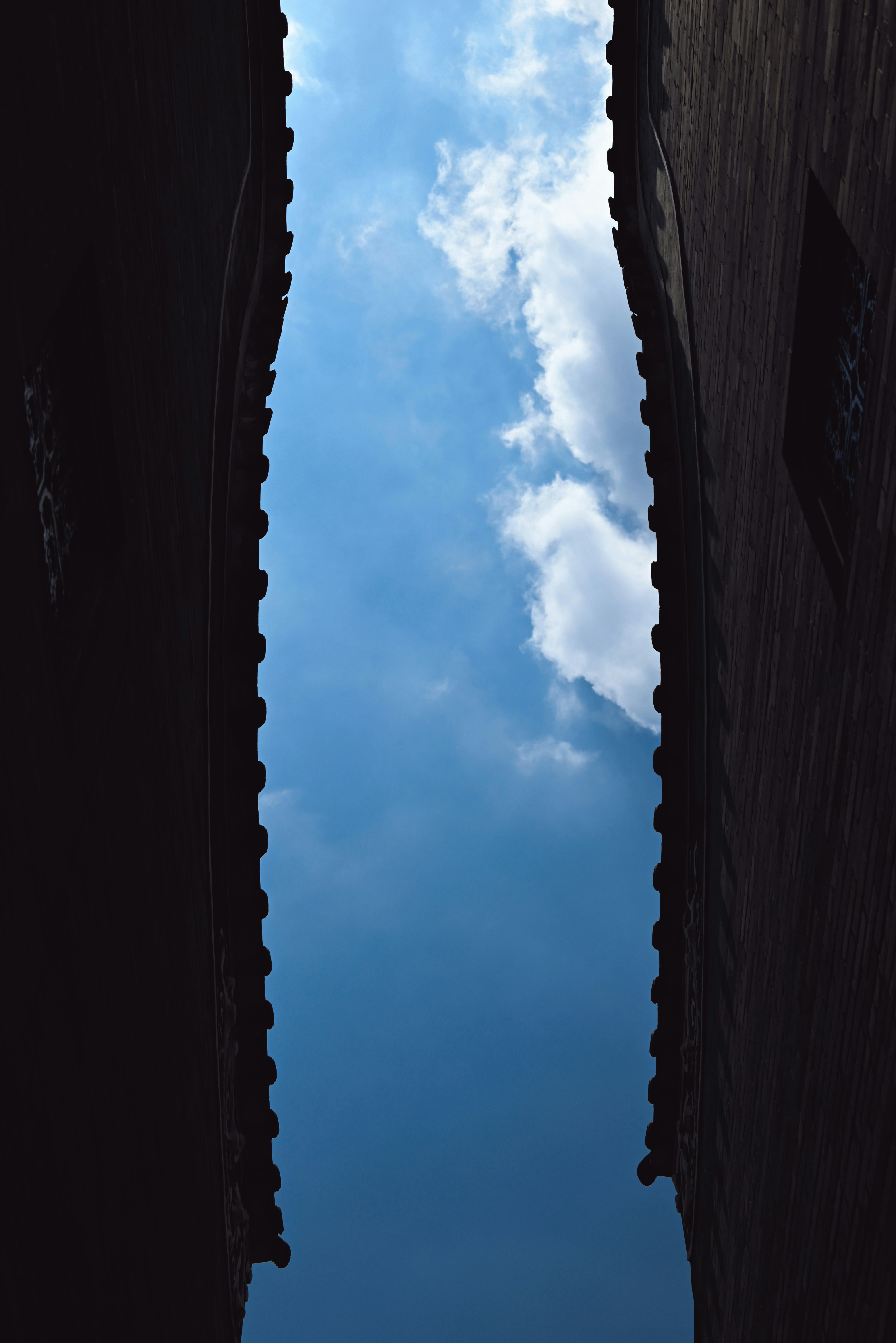 A view of the sky from between two buildings photo – Free Nature Image ...