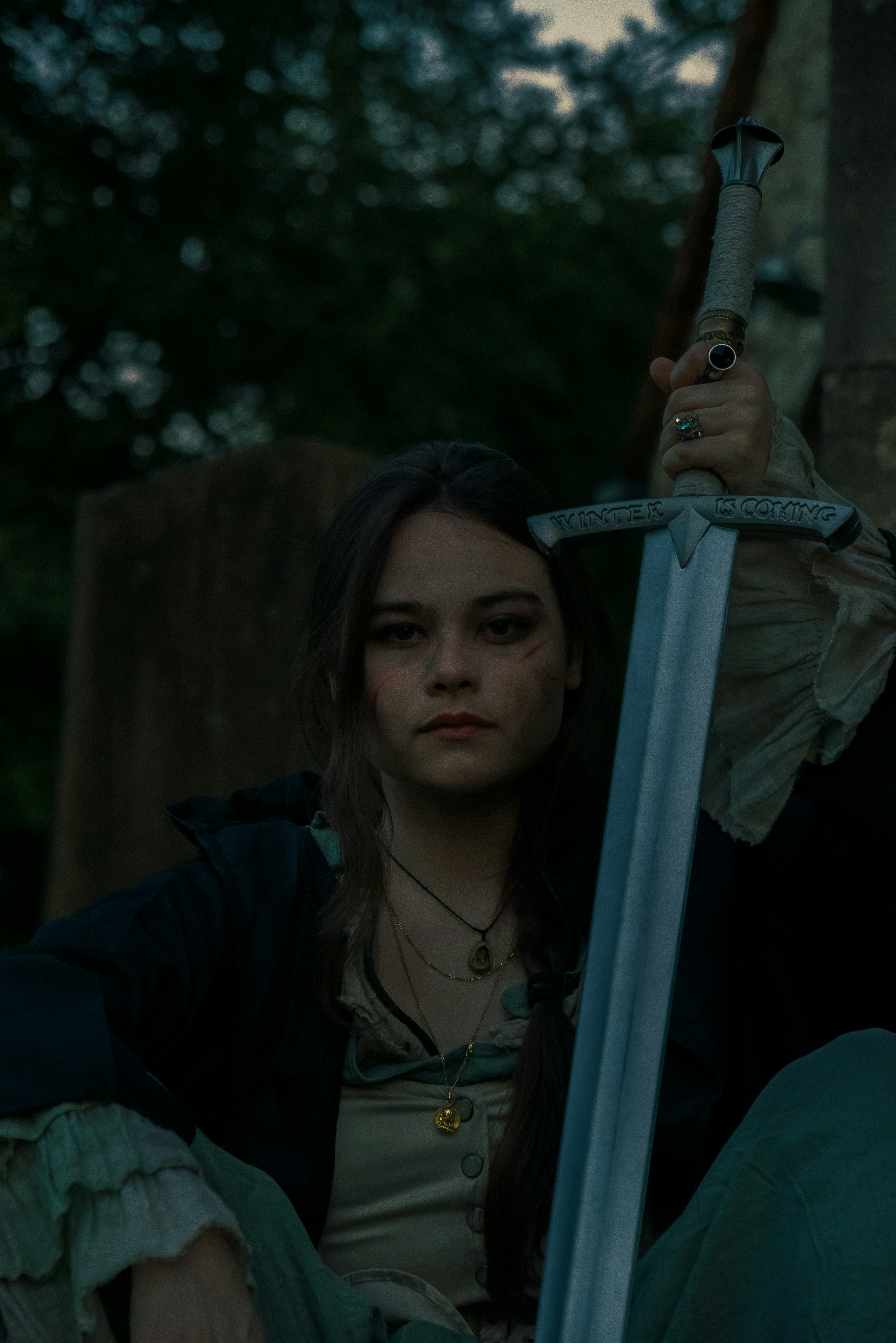 A woman with a sword sitting on the ground photo – Free Sword Image on ...