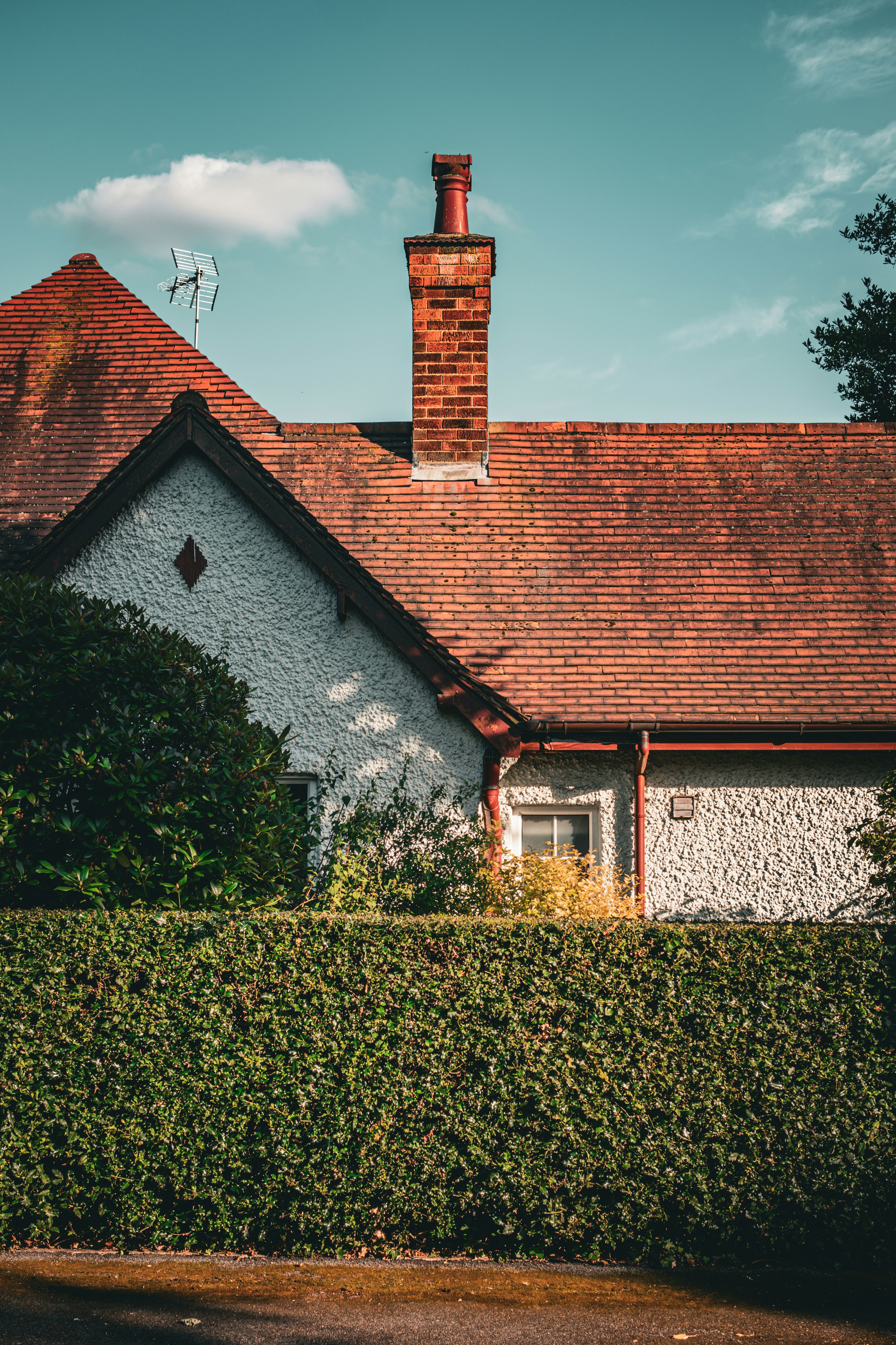 a white house with a red roof and a red chimney