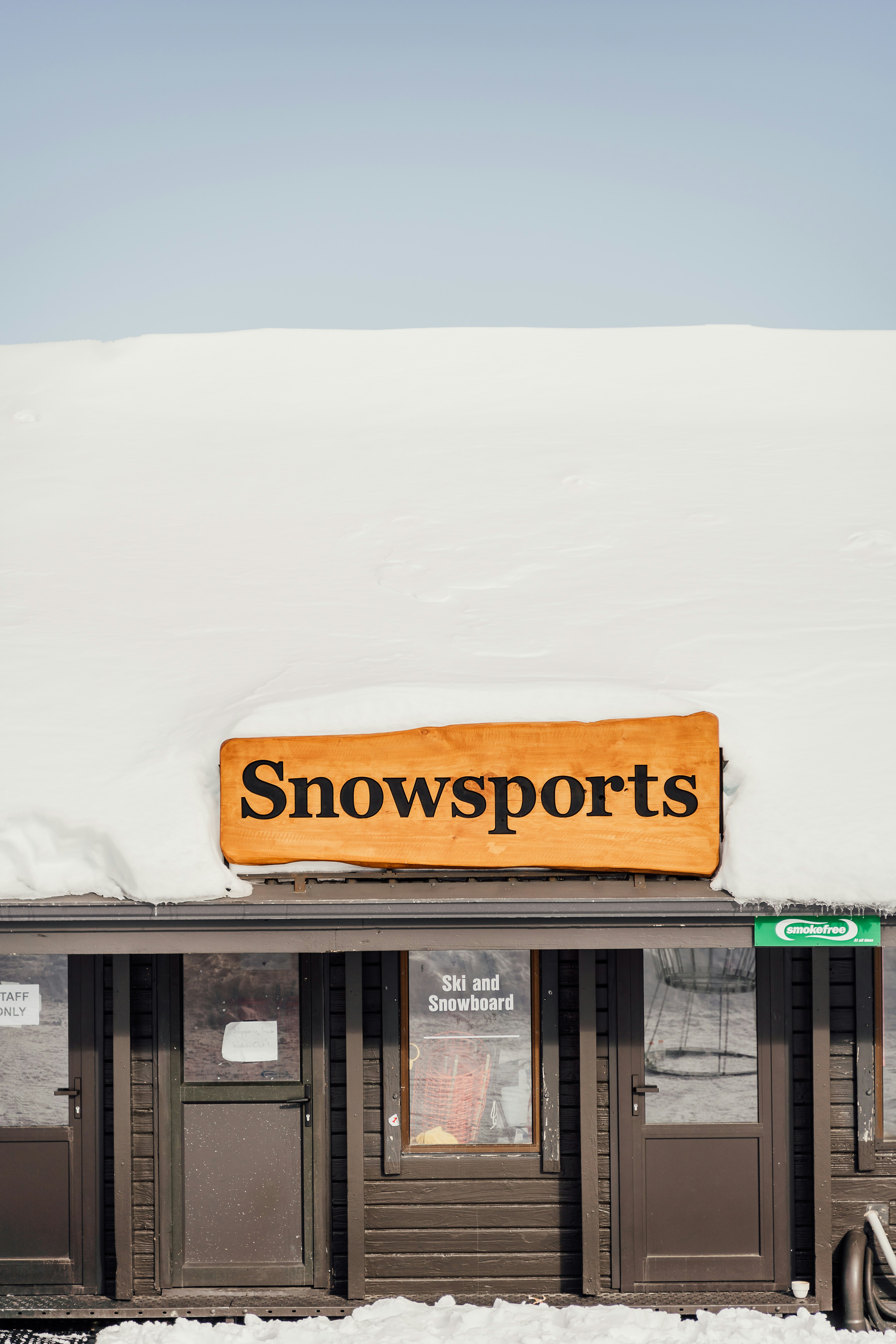 A snow sports store with a sign on the roof photo – Free Shelter Image ...