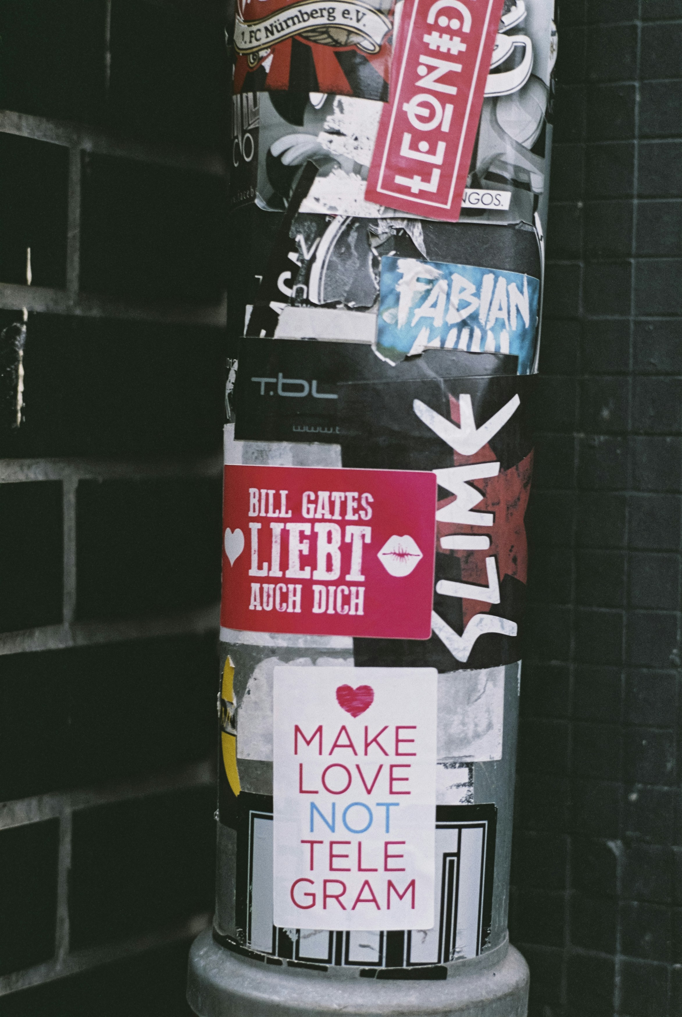 A pole with a bunch of stickers on it photo – Free Film photography ...