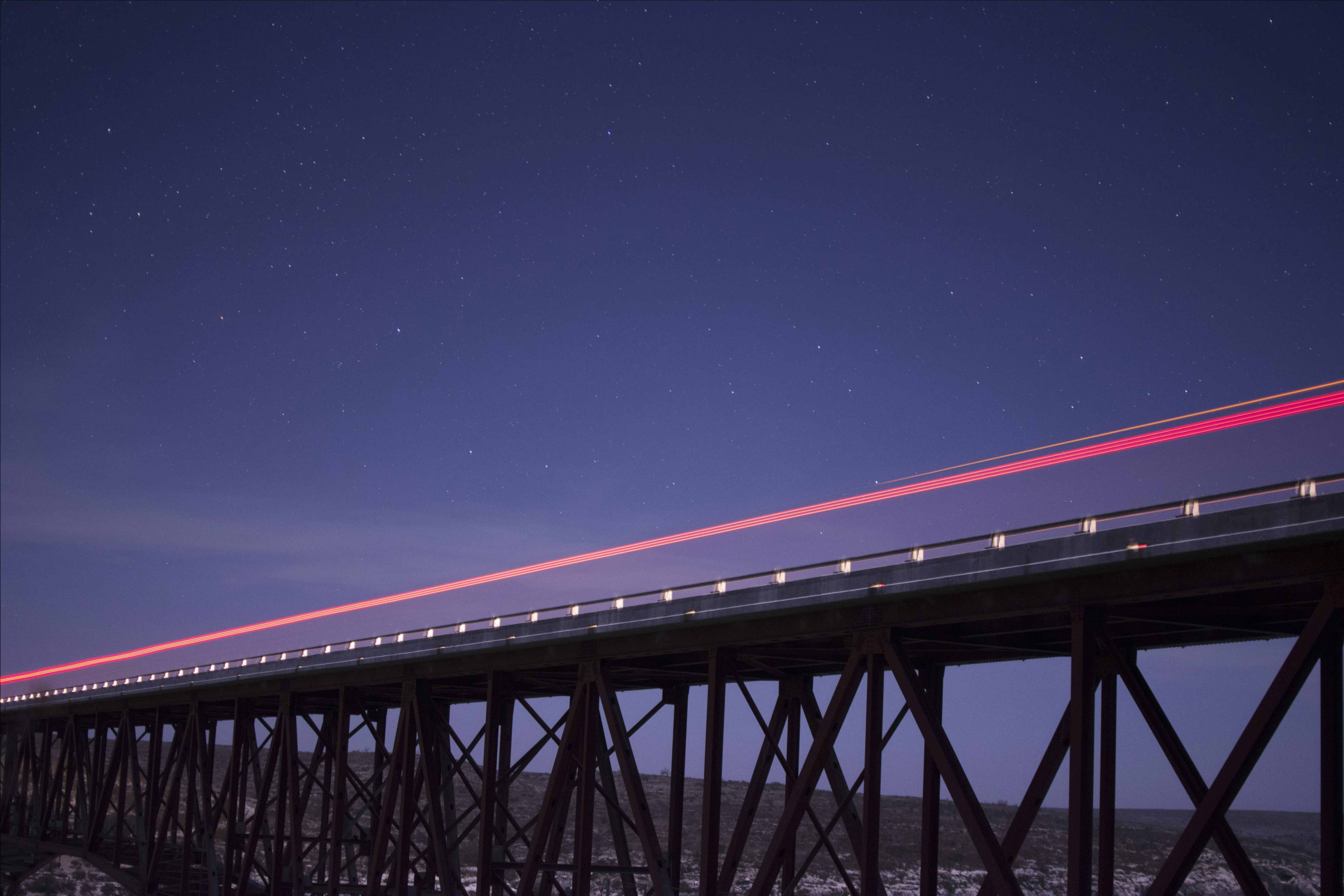 A train traveling over a bridge at night photo – Free Night Image on ...