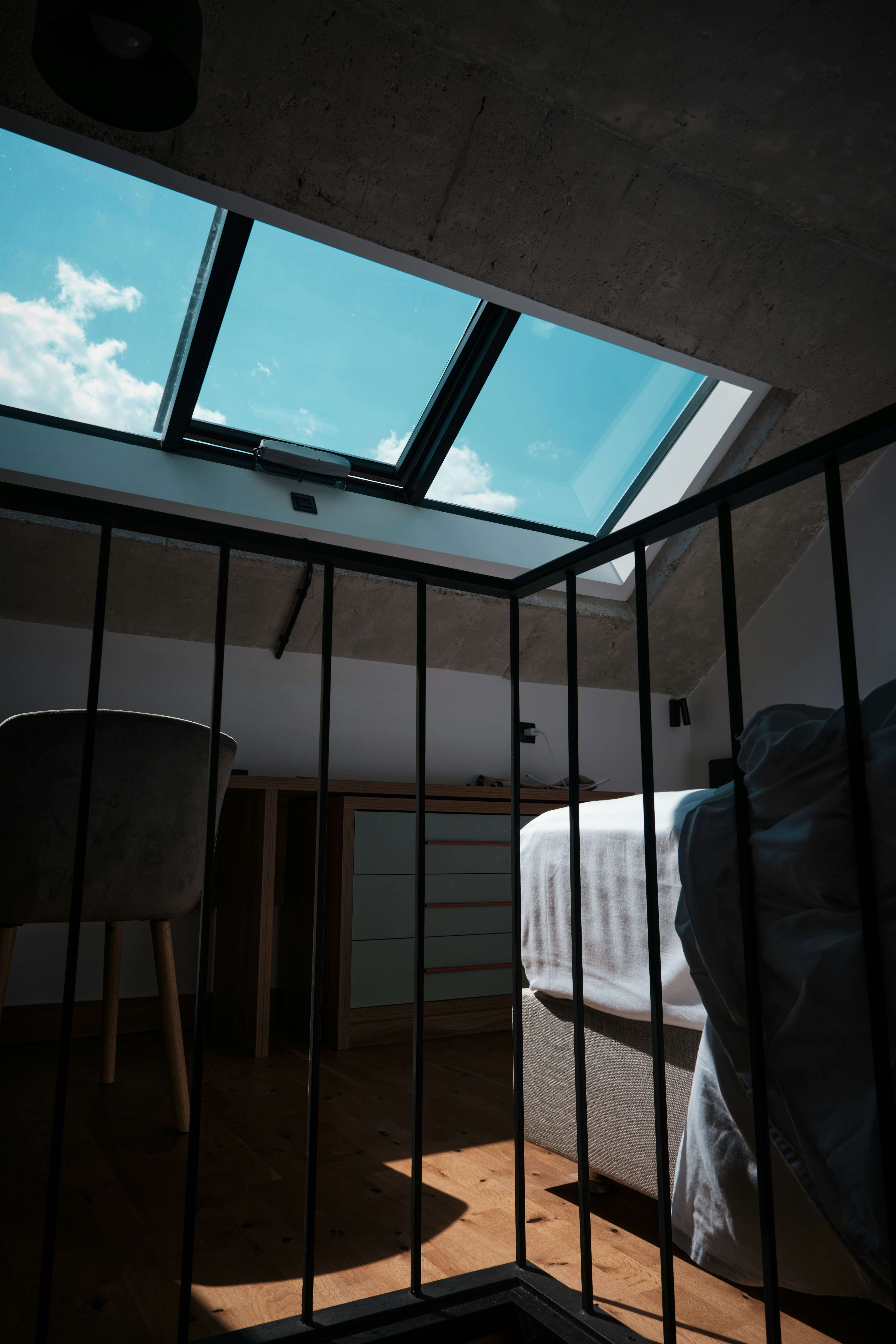 Sunlit Sky through a Loft Window above a Quiet Bedroom