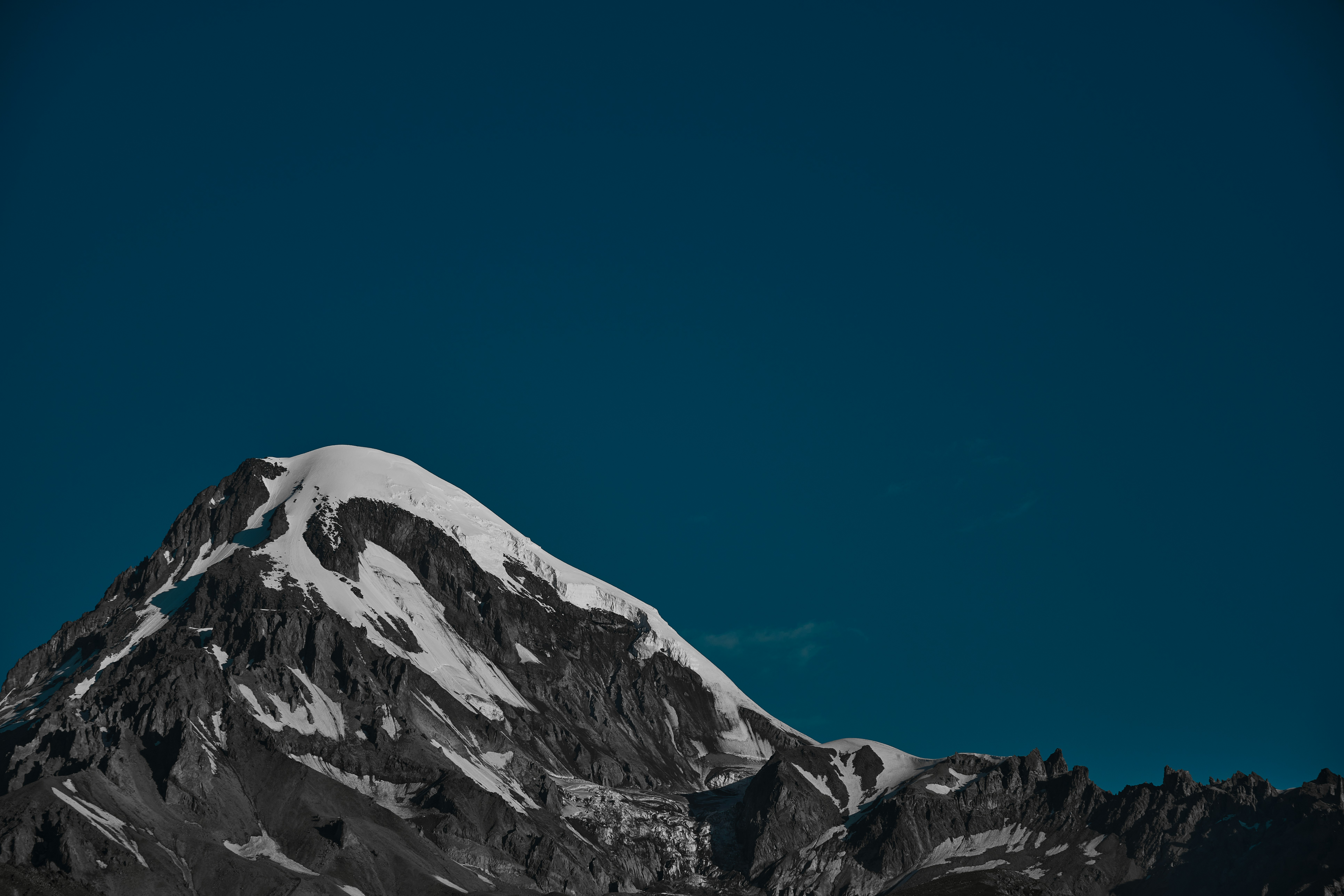 Indigo Alpine: Snow-veiled Peak Under a Pristine Sky