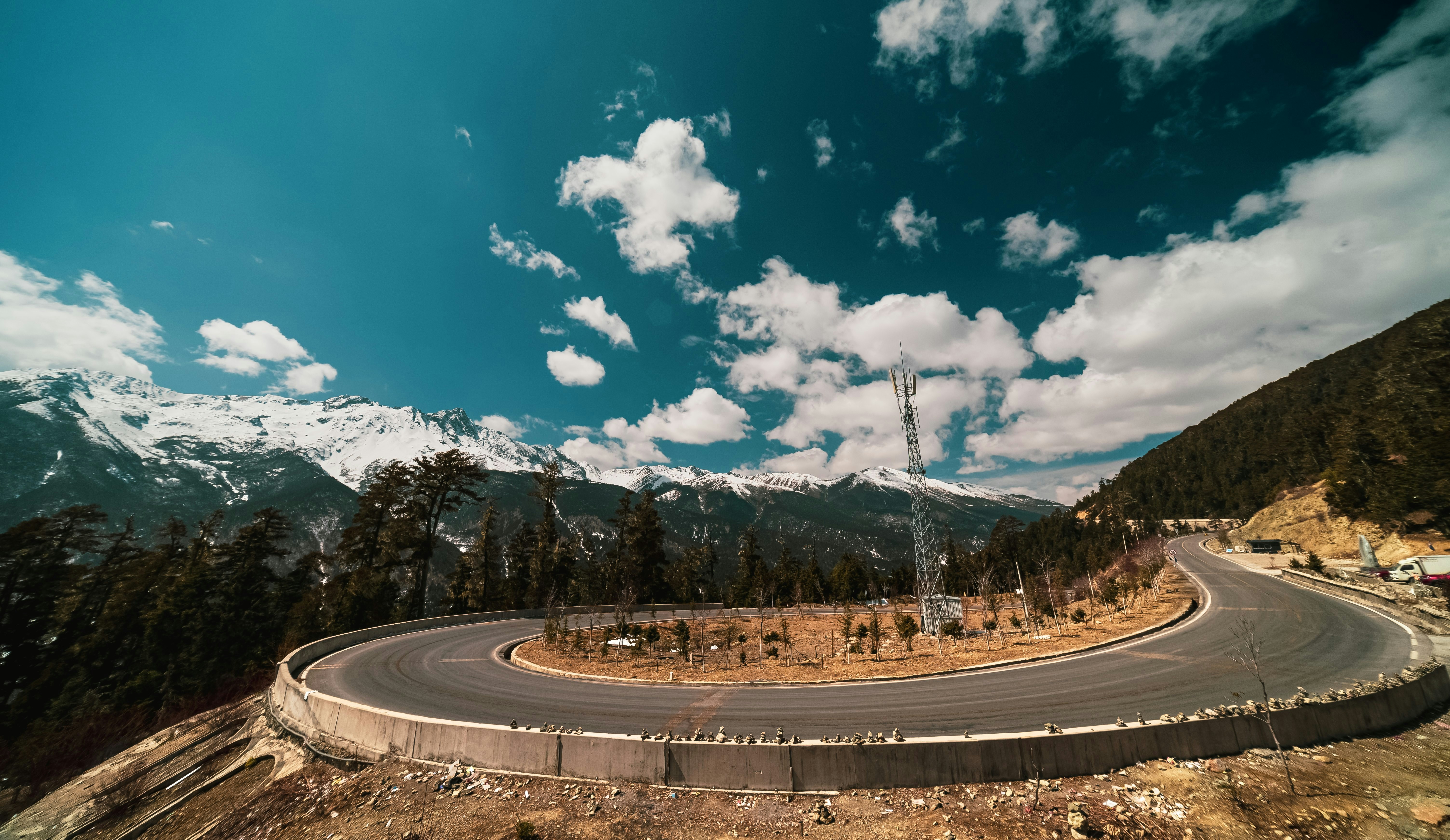 A curved road with mountains in the background photo – Free Road Image ...