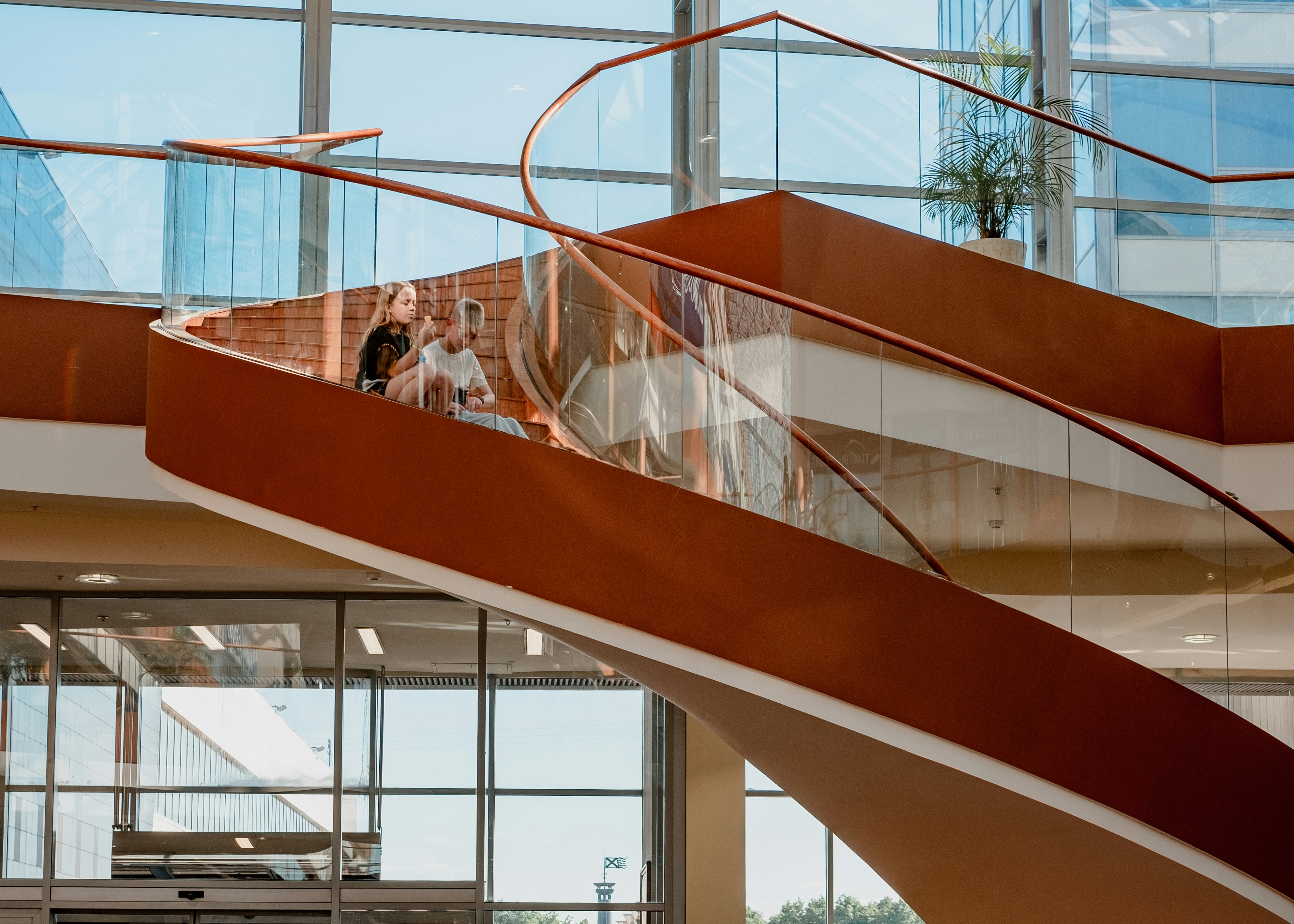 Two Figures on a Citrus Spiral in a Glass Atrium