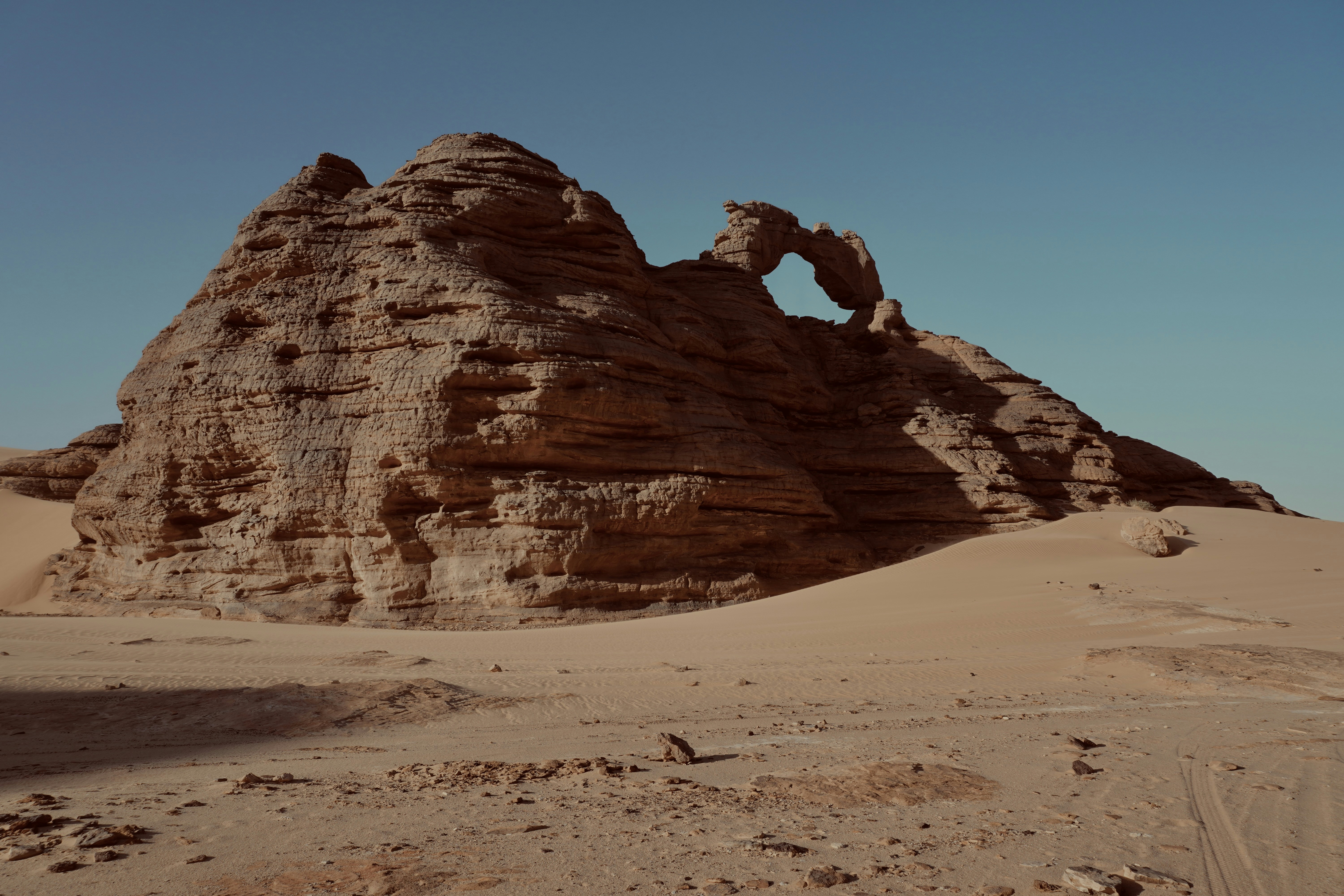 Une grande formation rocheuse au milieu d’un désert photo – Image ...