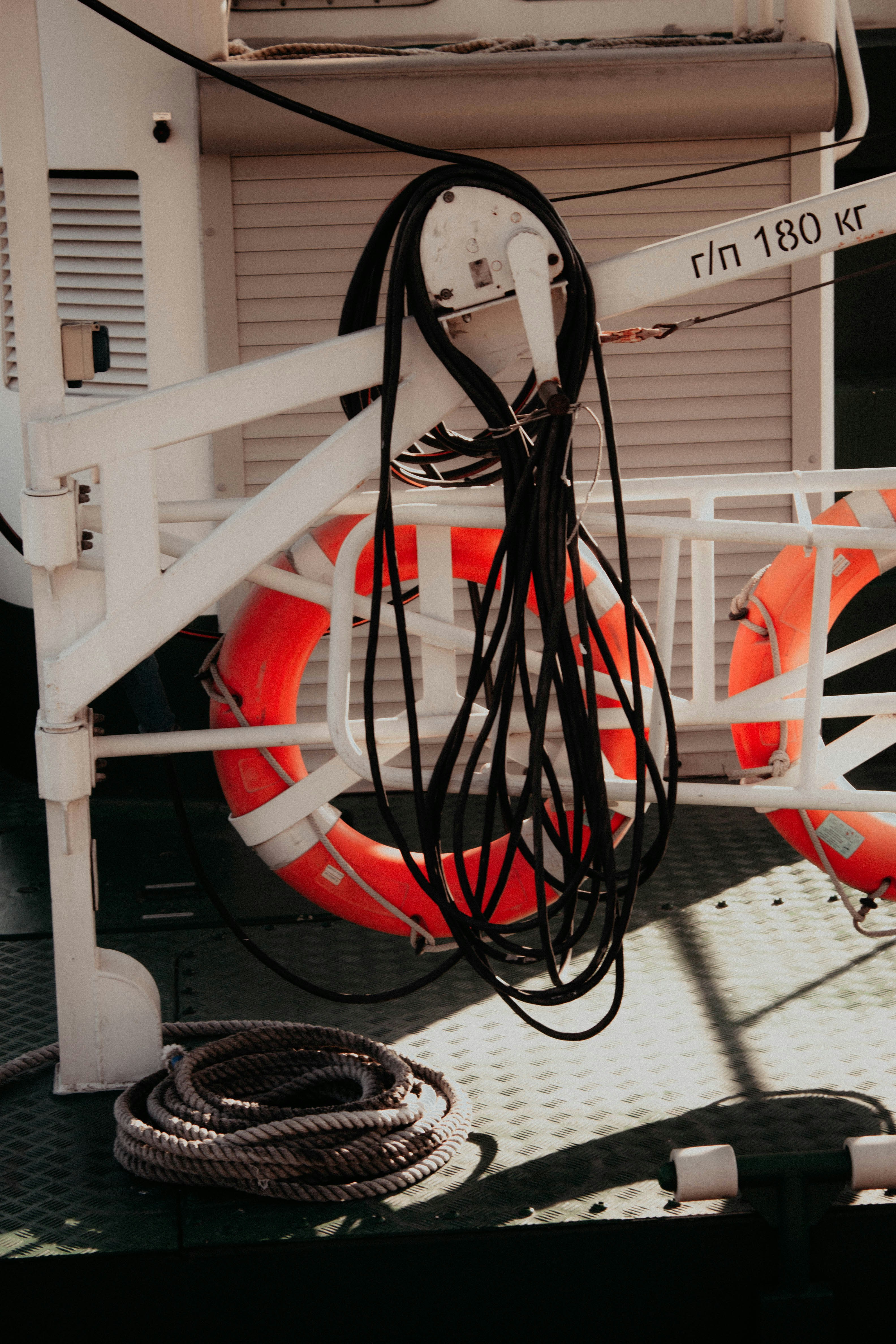Pulley Portrait: Tangled Cables and Orange Buoys on a Maritime Deck