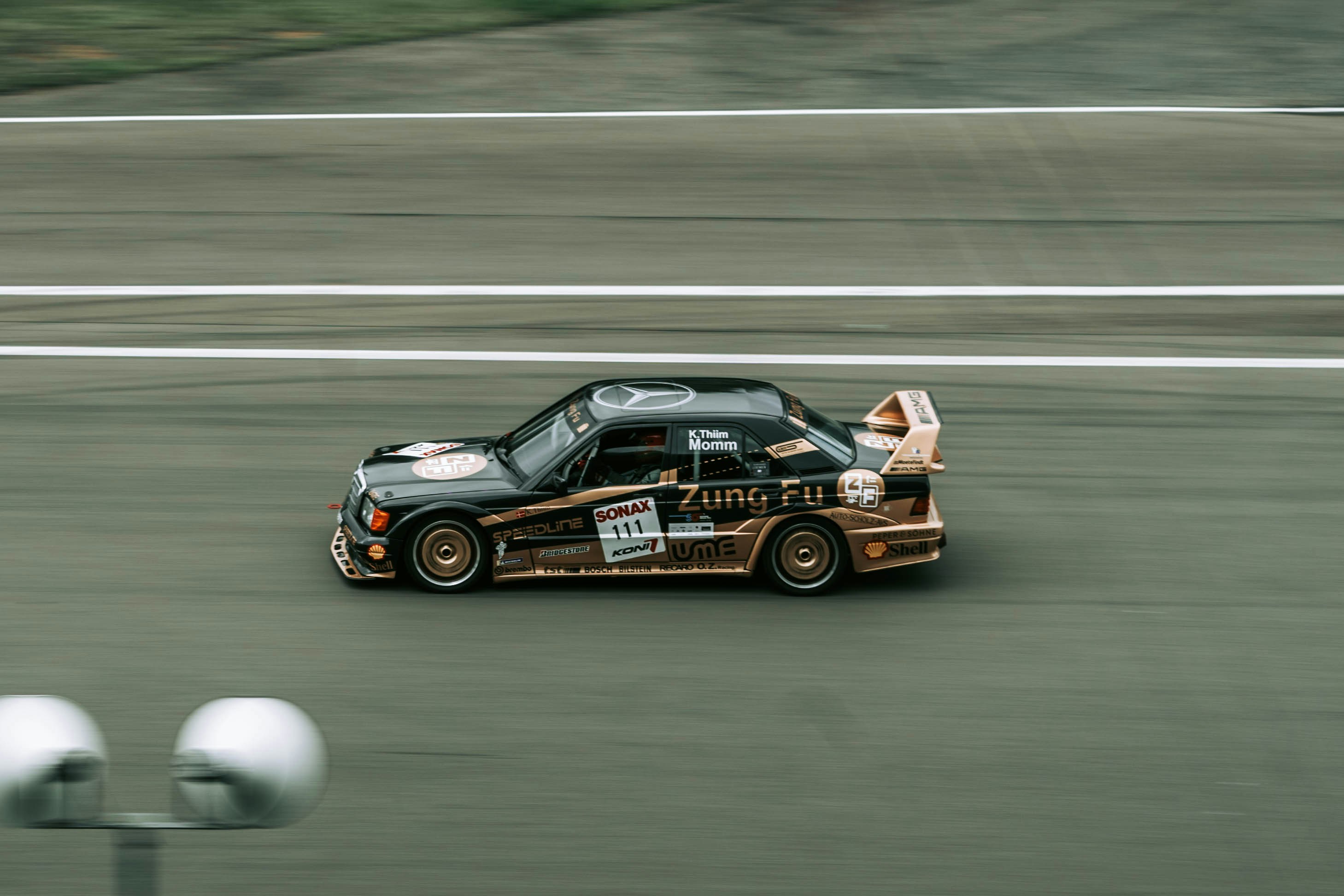 A car driving down a race track with a person in the back of it photo ...