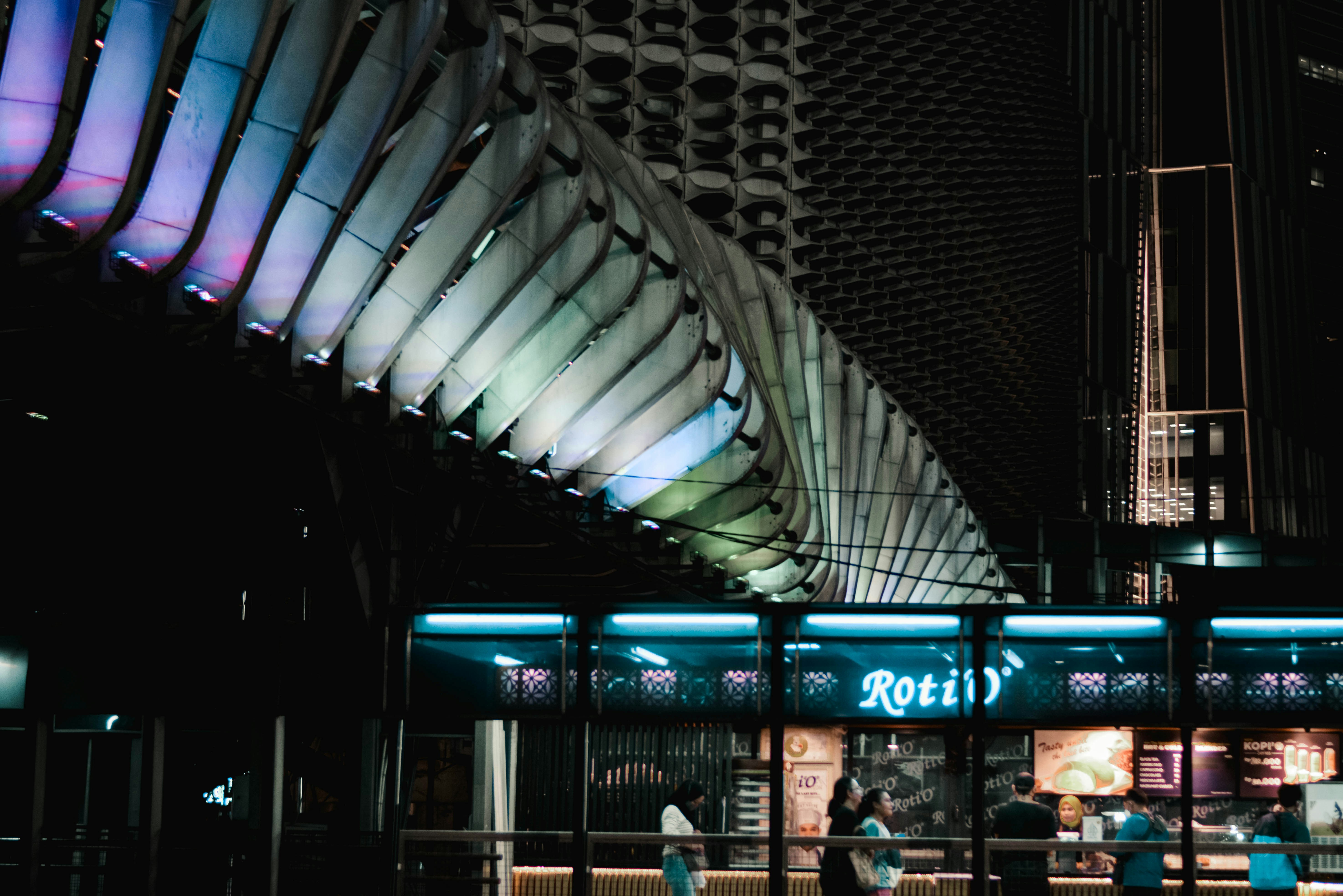 Neon Beneath the Ribbed Canopy: Nightlife Under the Curved Arch