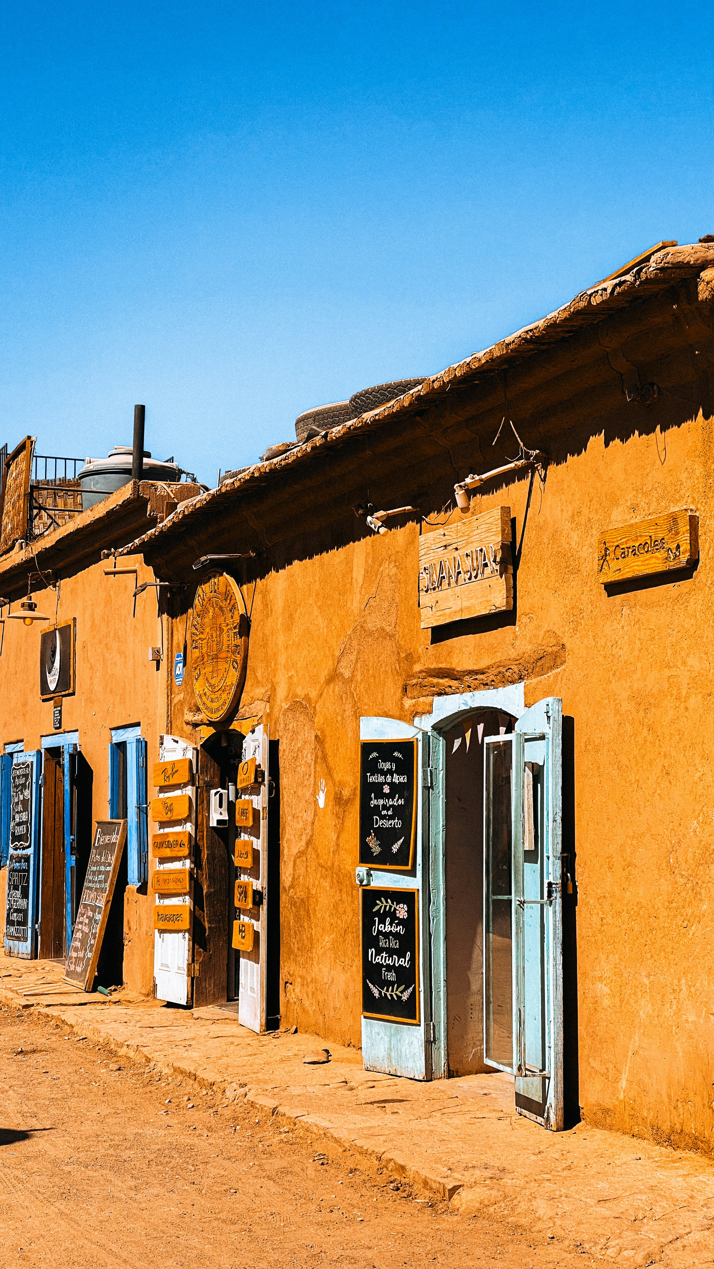 Sunlit Adobe Lane: A Palette of Orange and Sky