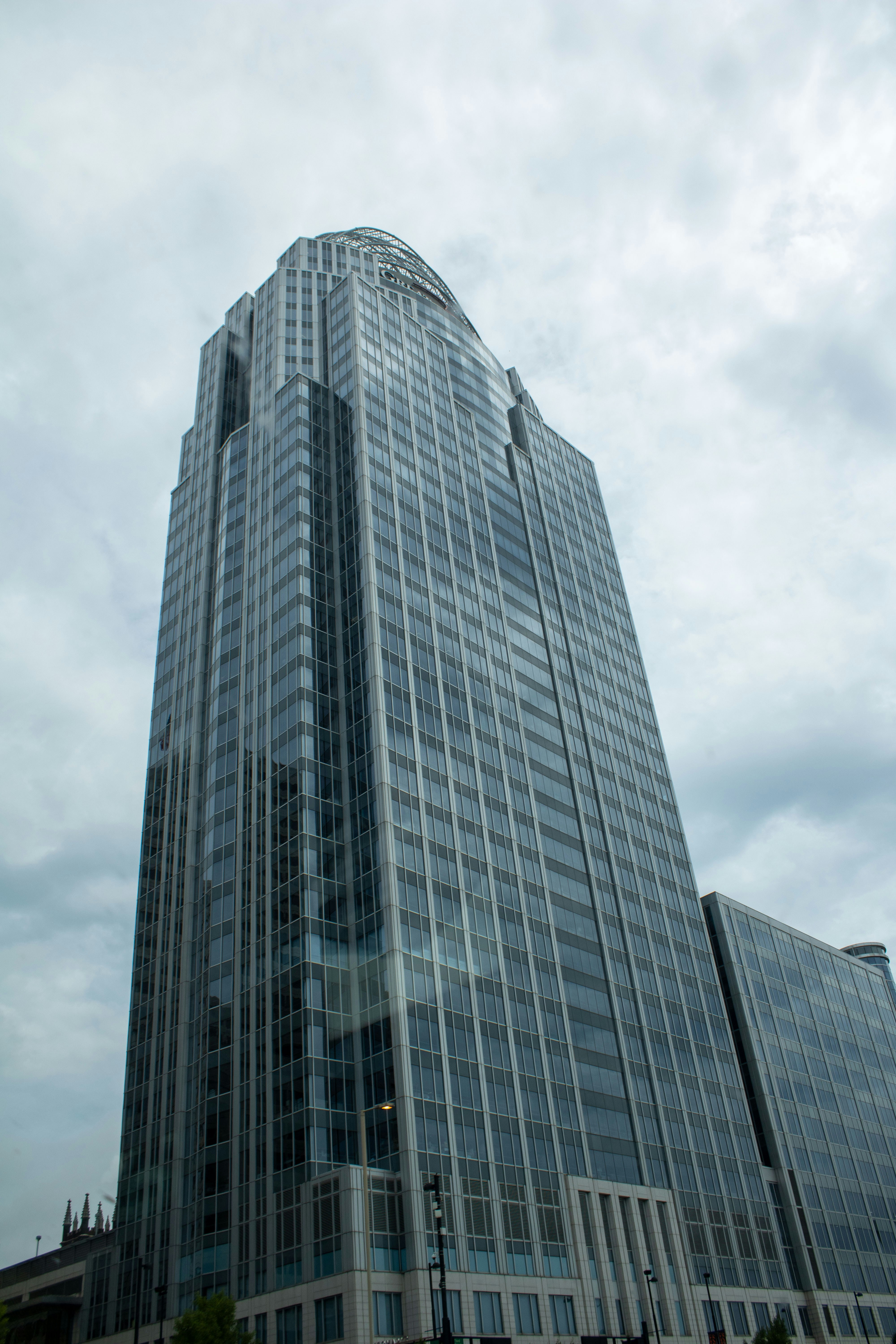 Skyward Prism: A Glass Tower Rising Through a Clouded Horizon
