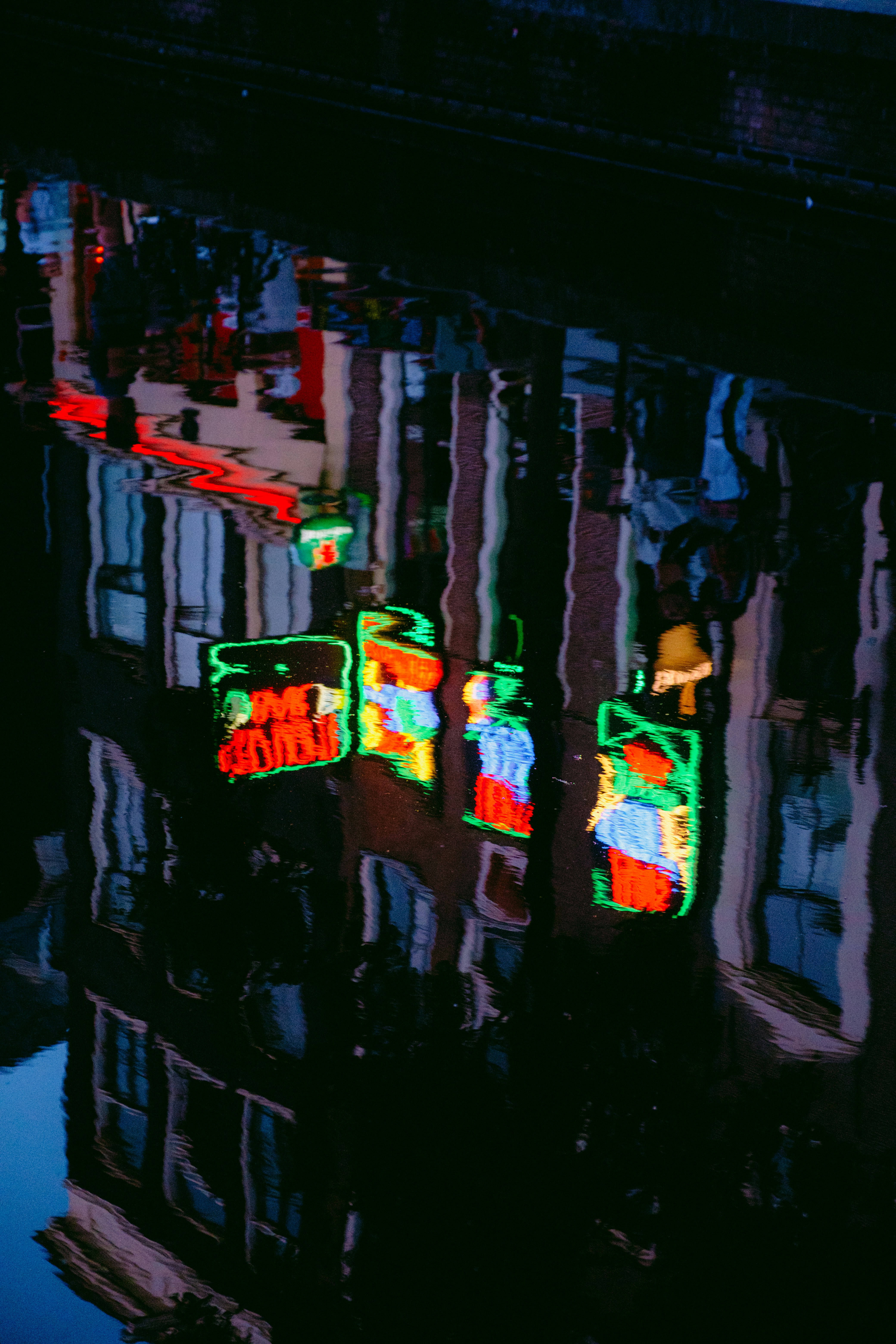 Neon Ripples: Reflections of a City's Quiet After Dark
