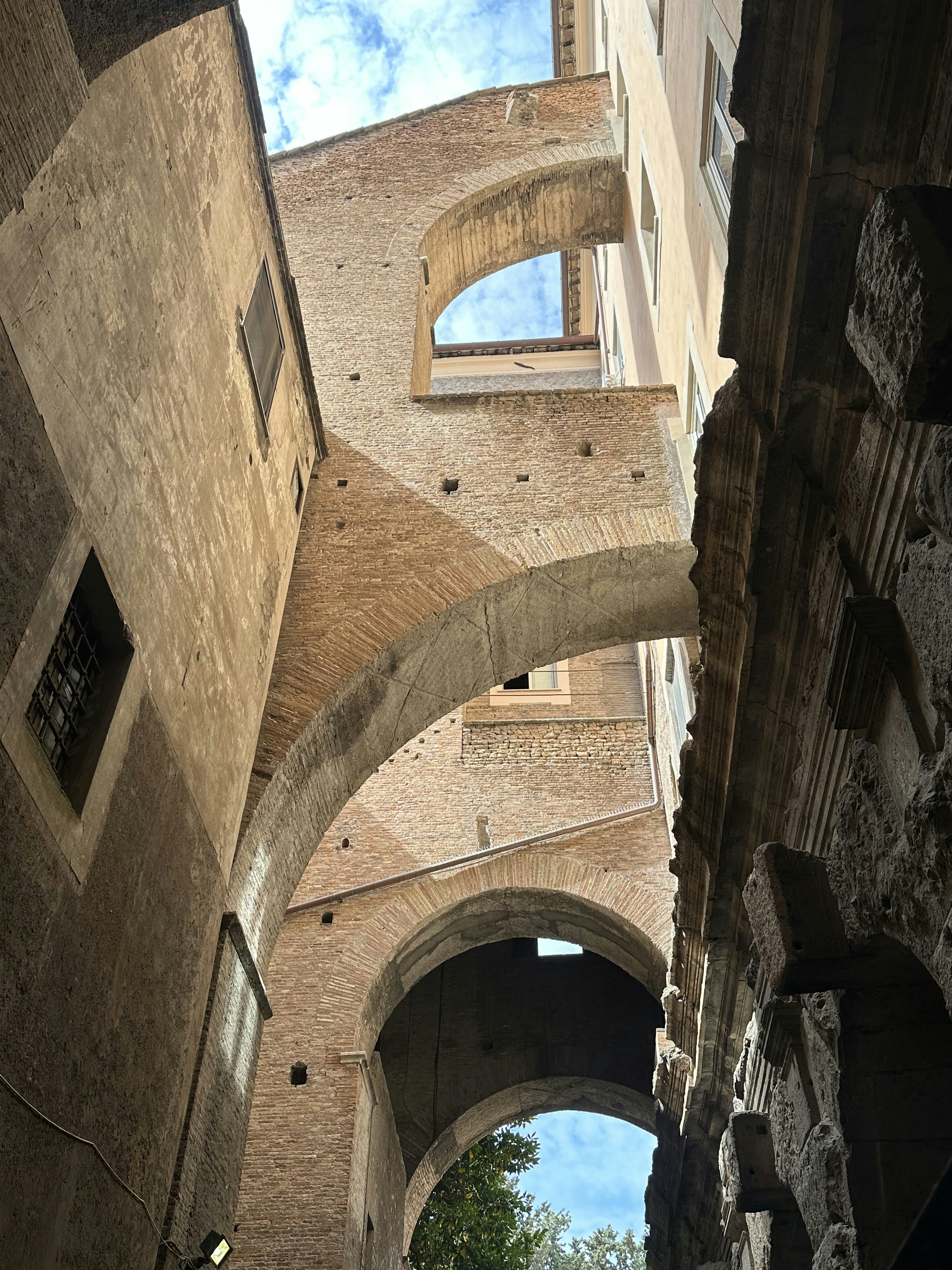 A narrow alley with arches and a clock tower in the background photo ...