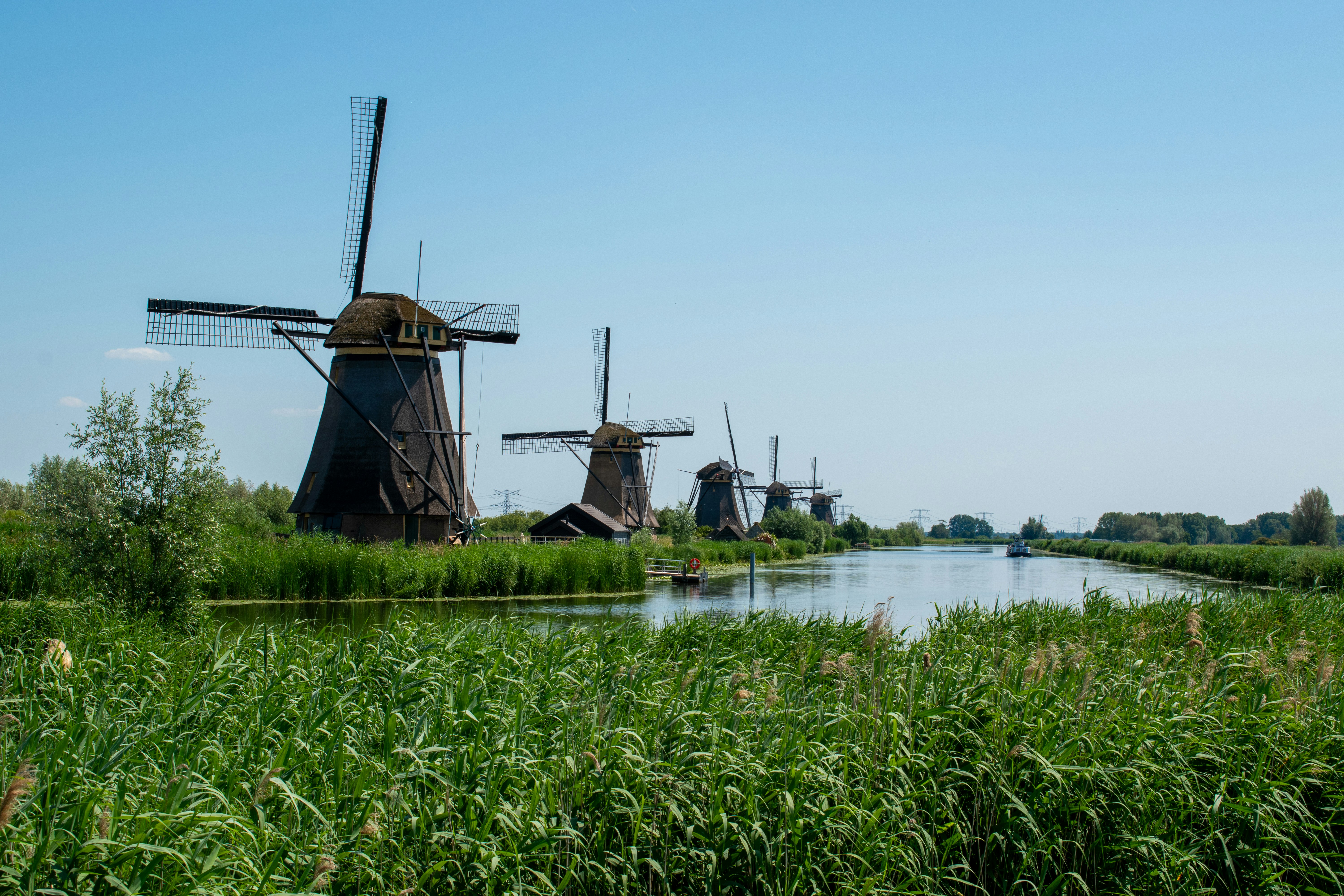 A row of windmills sitting next to a river photo – Free Kinderdijk Image on Unsplash