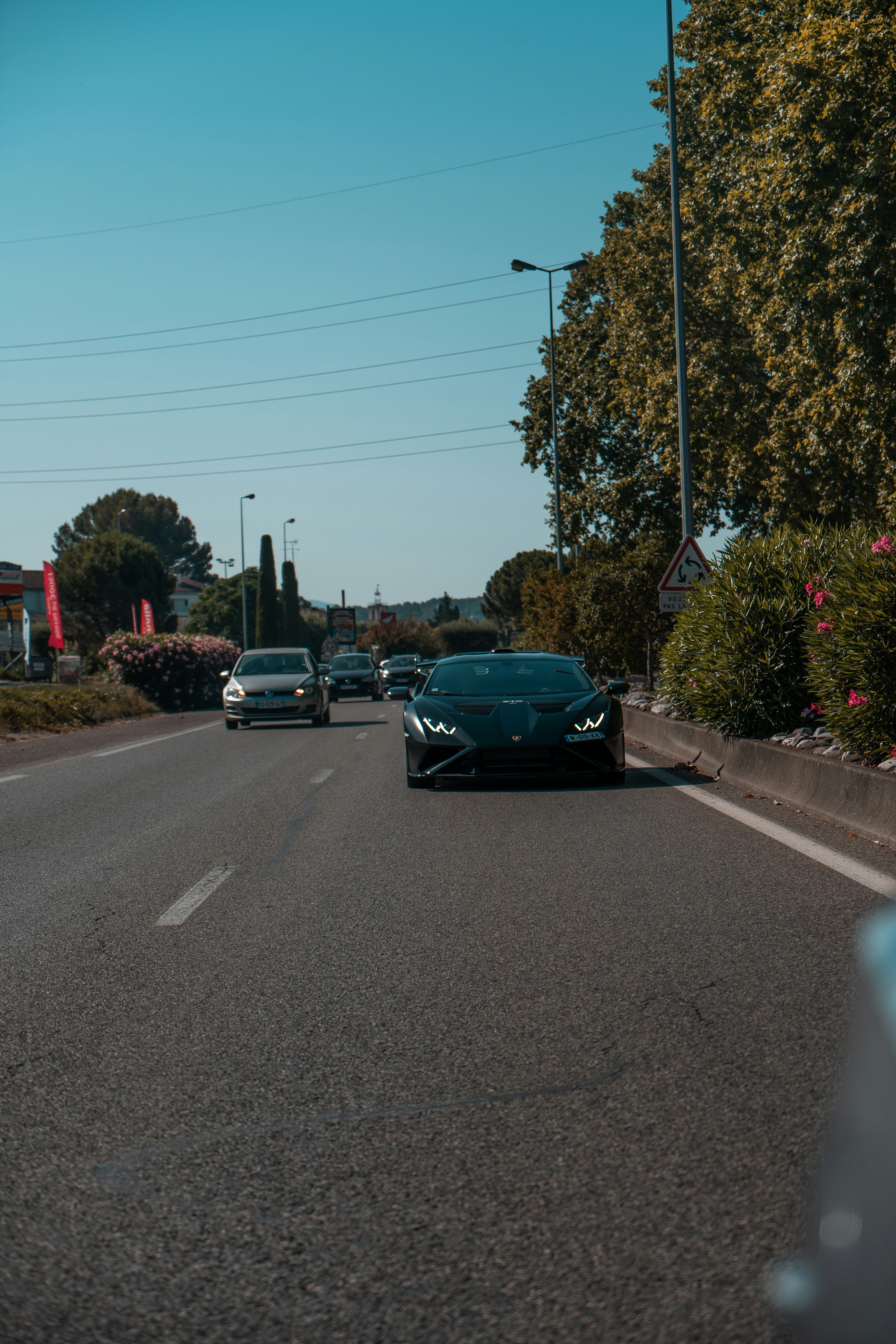 Midday Velocity: A Black Sports Coupe Dominates a Sunlit Suburban Road
