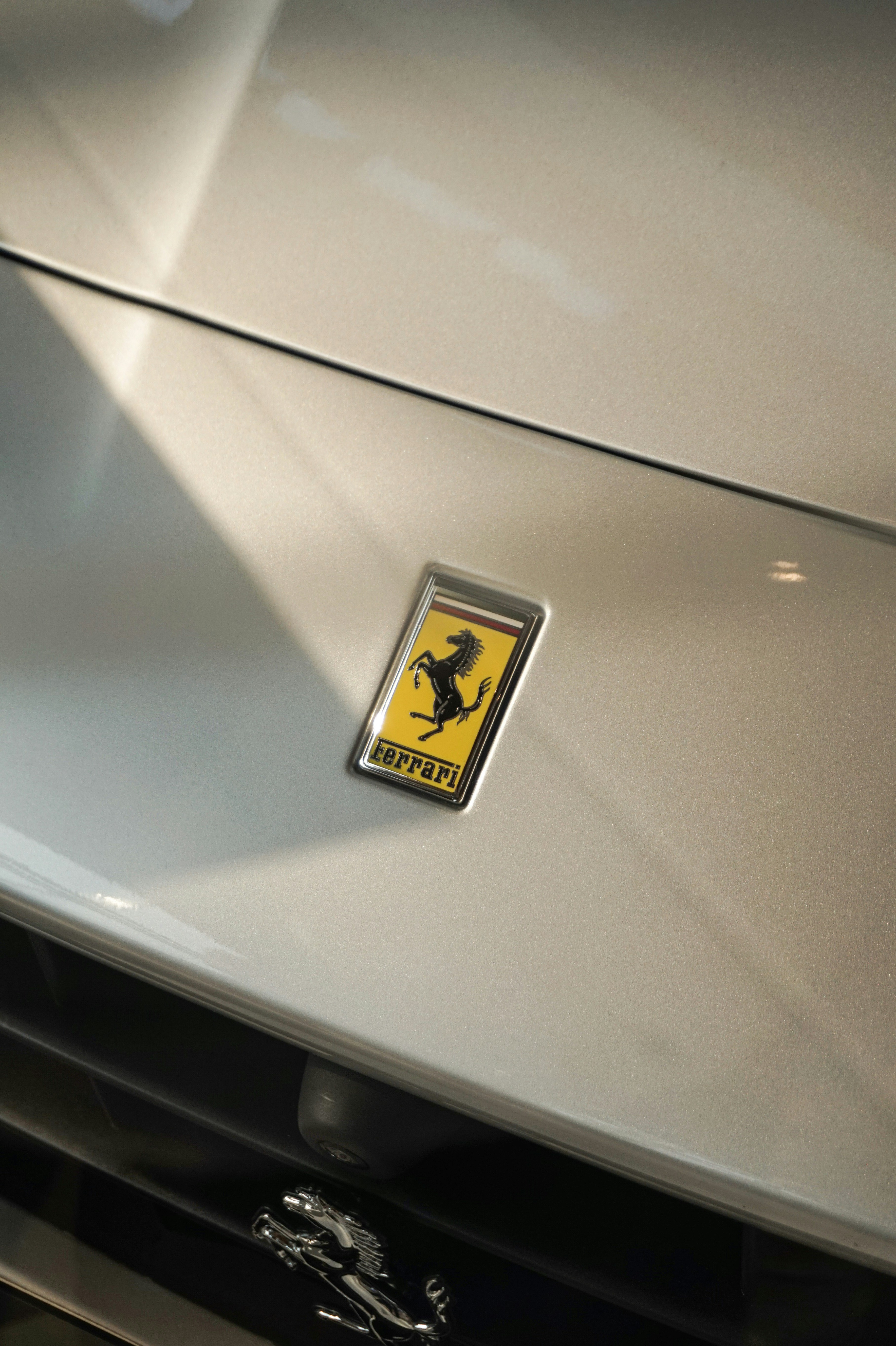 A ferrari badge on the front of a silver car photo – Free Badge Image ...