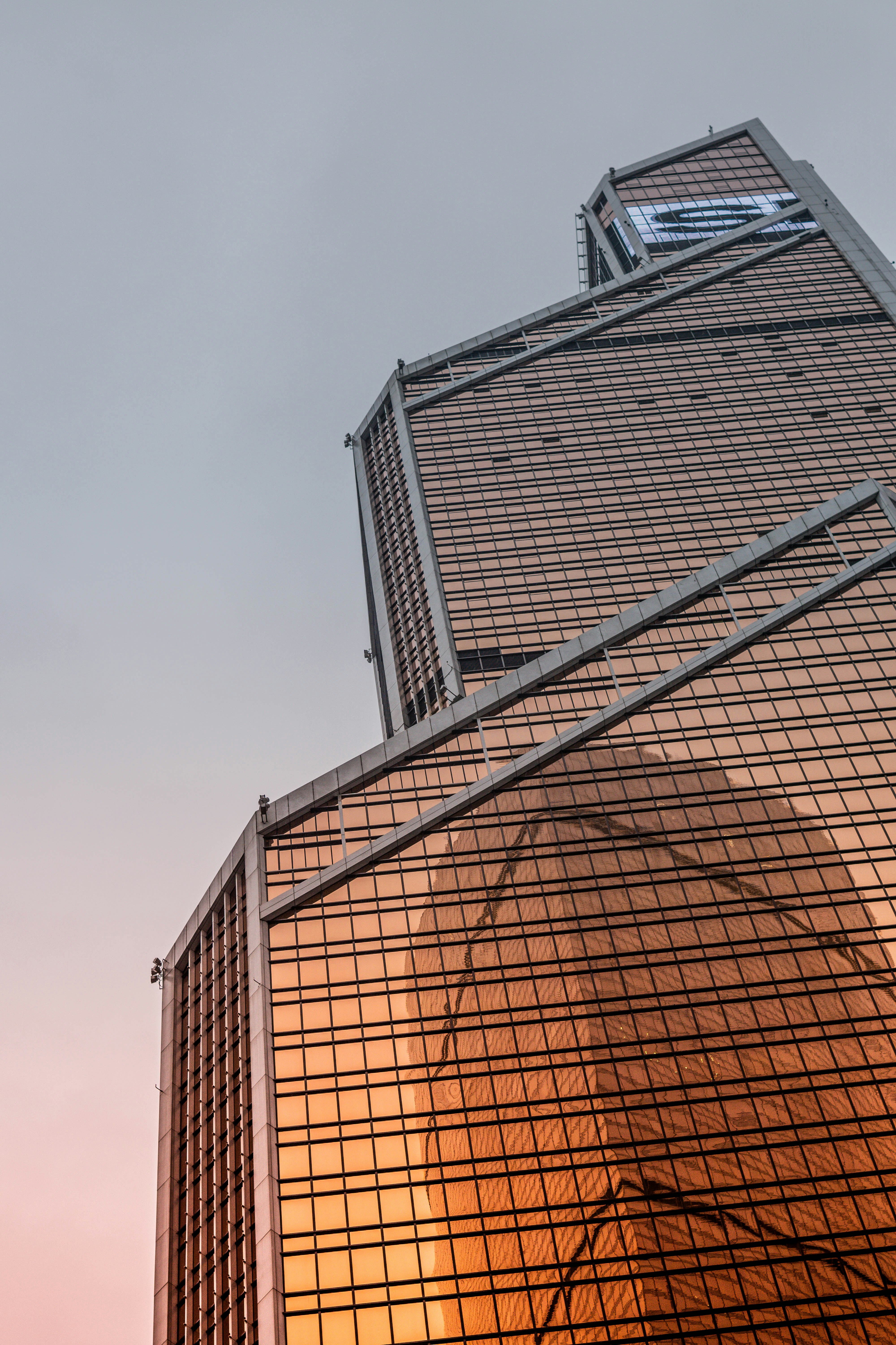 Crimson Facade: Sunset Reflections on a Faceted Glass Tower