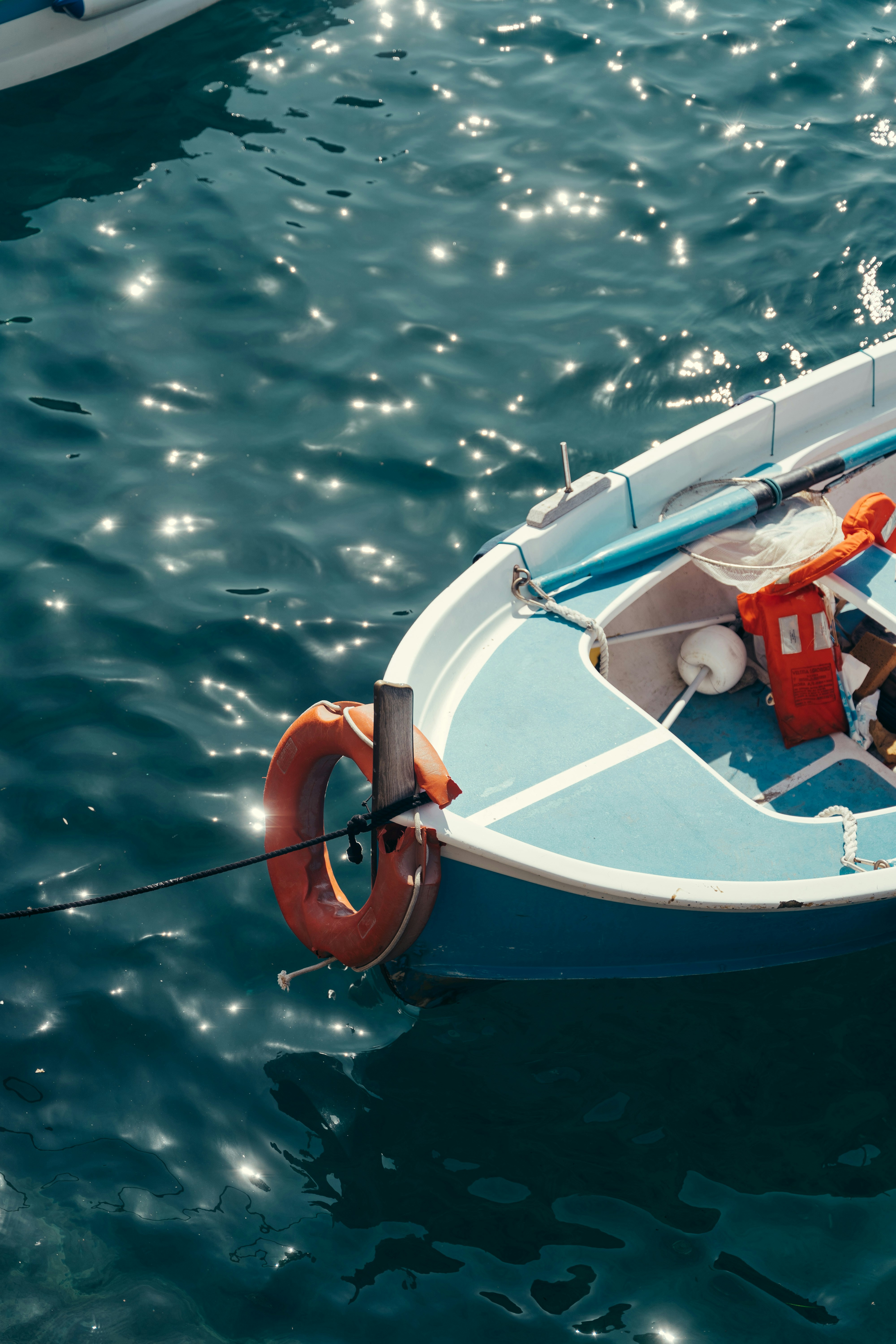 A small blue boat floating on top of a body of water photo – Free Sea ...