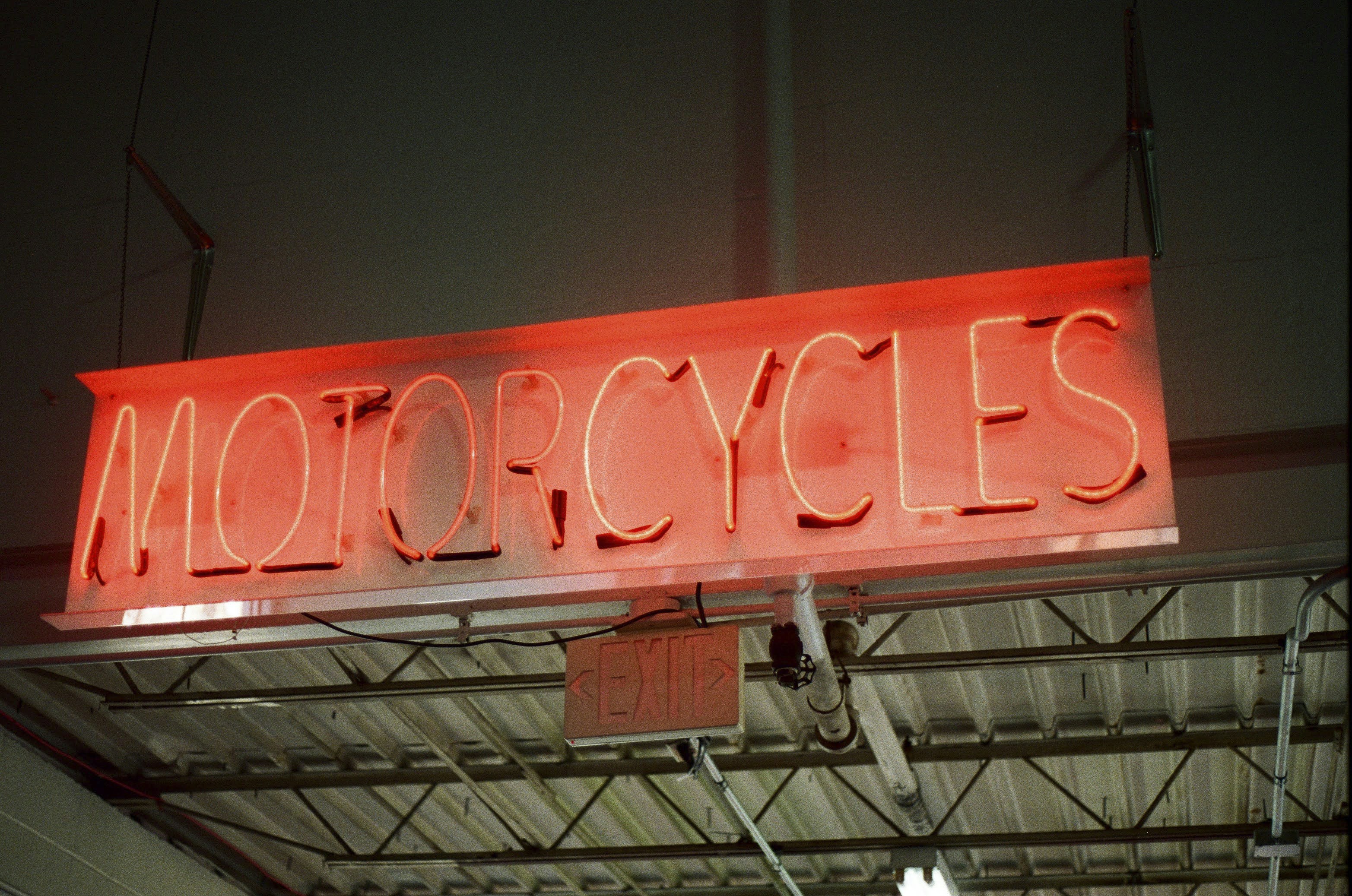 A neon sign that reads motorcycles hanging from a ceiling photo – Free ...