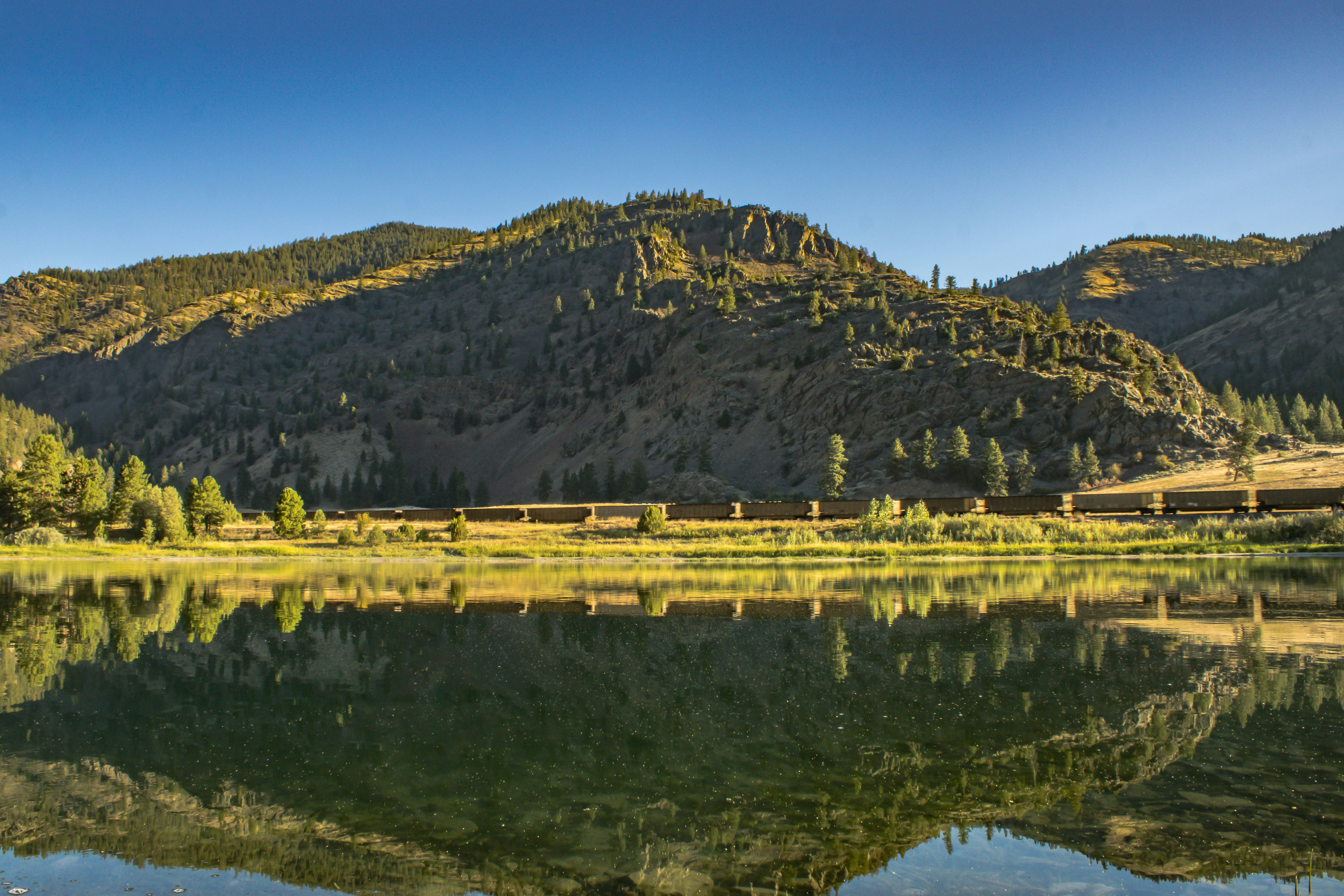 A scenic view of a mountain with a lake in the foreground photo – Free ...