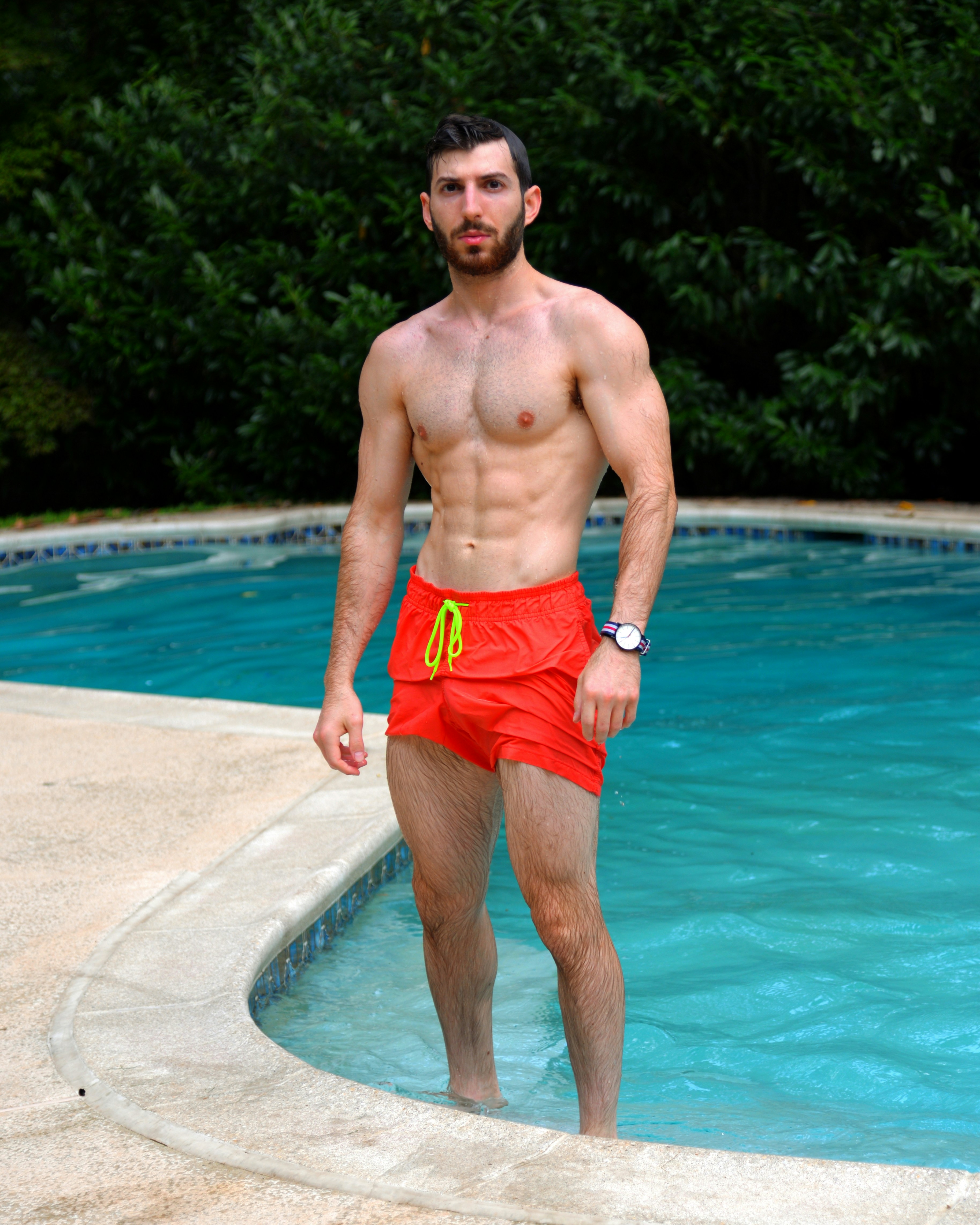 Poolside Stance: Quiet Strength in Crimson Swim Shorts